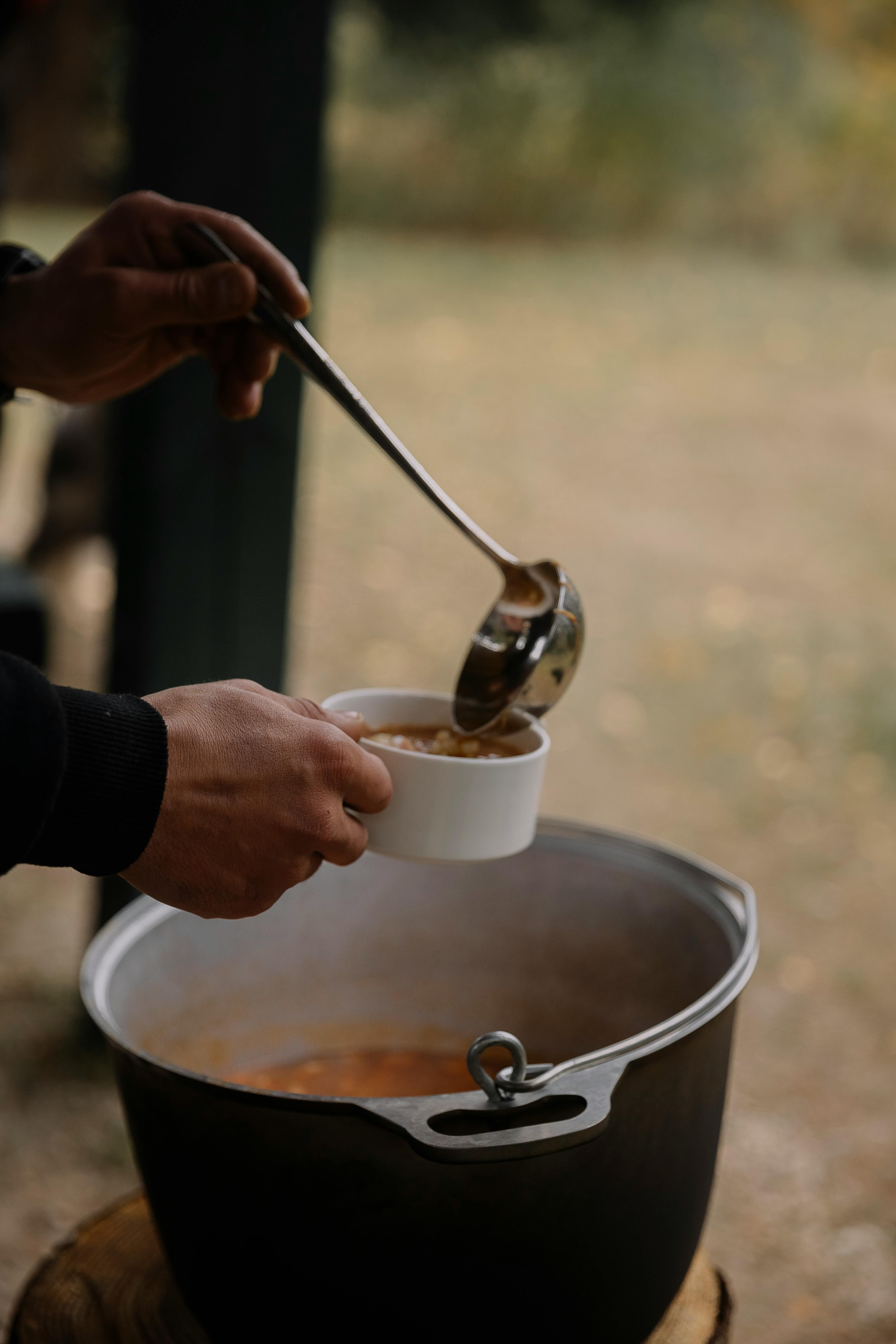 Hands of a Person Taking some Hot Stew from a Pot · Free Stock Photo