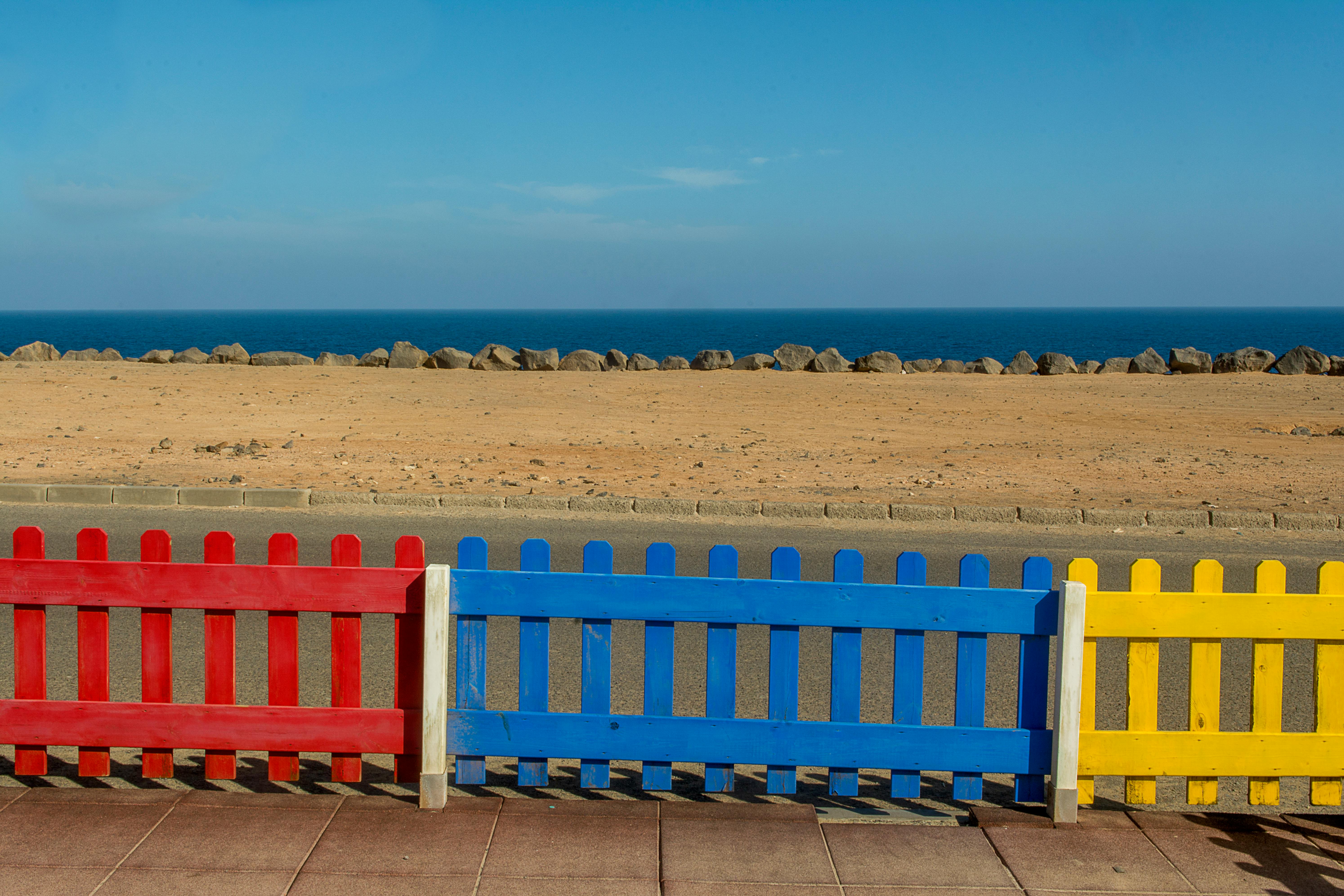 Colorful Picket Fence in front of a Beachside Road · Free Stock Photo