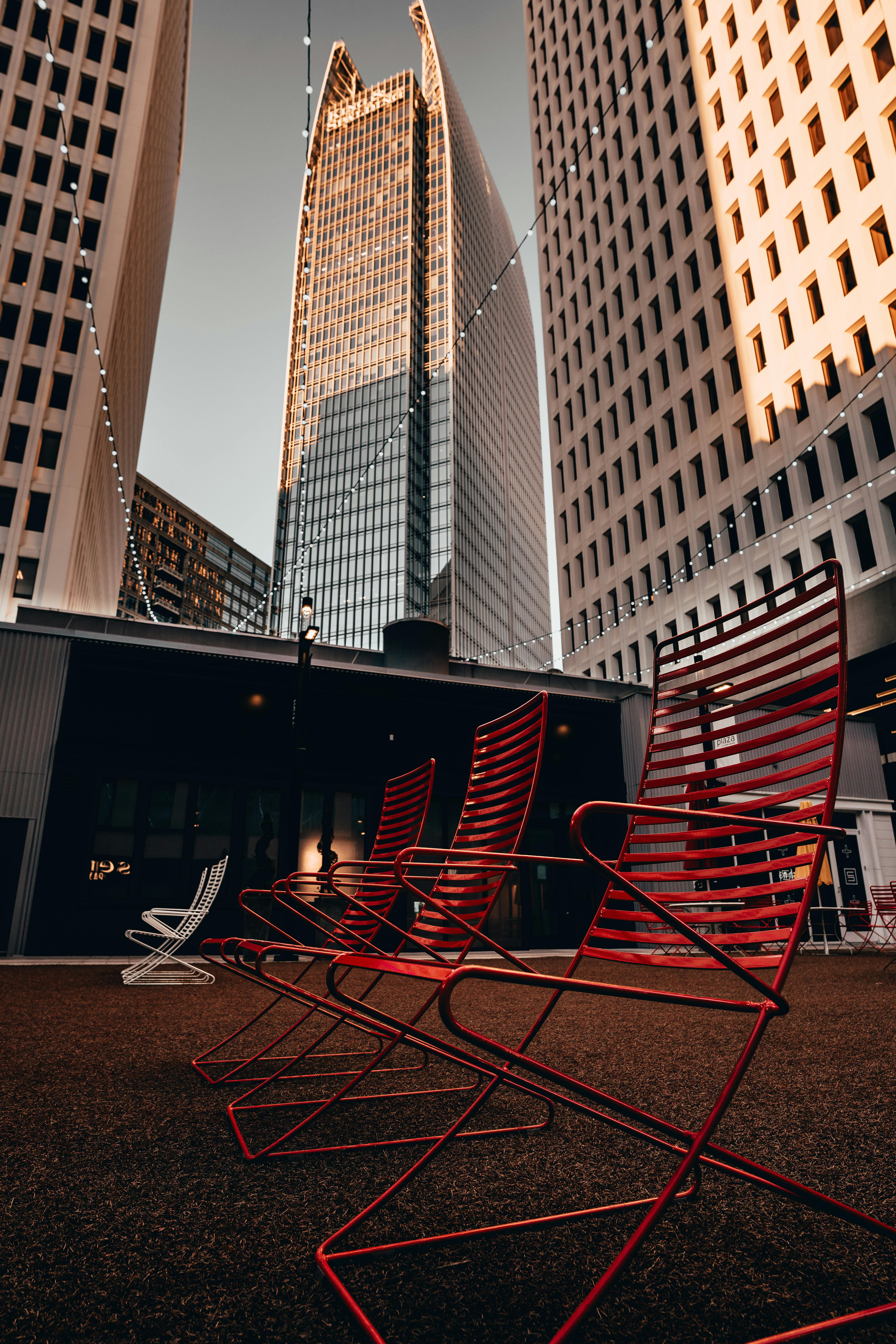 Elegant Red Metal Chairs Standing at a Plaza near Skyscrapers in ...