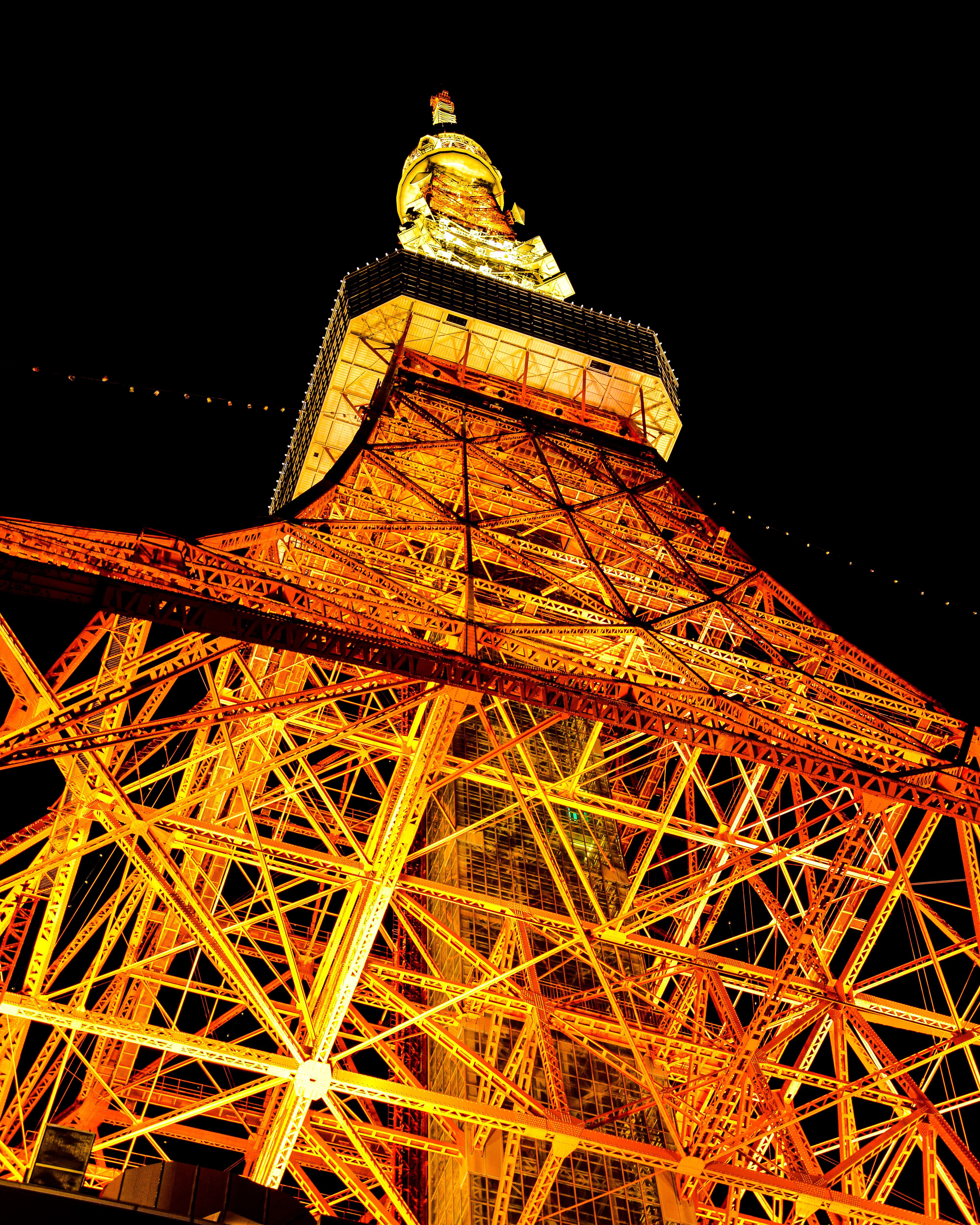 A tower with a yellow light shining on it · Free Stock Photo