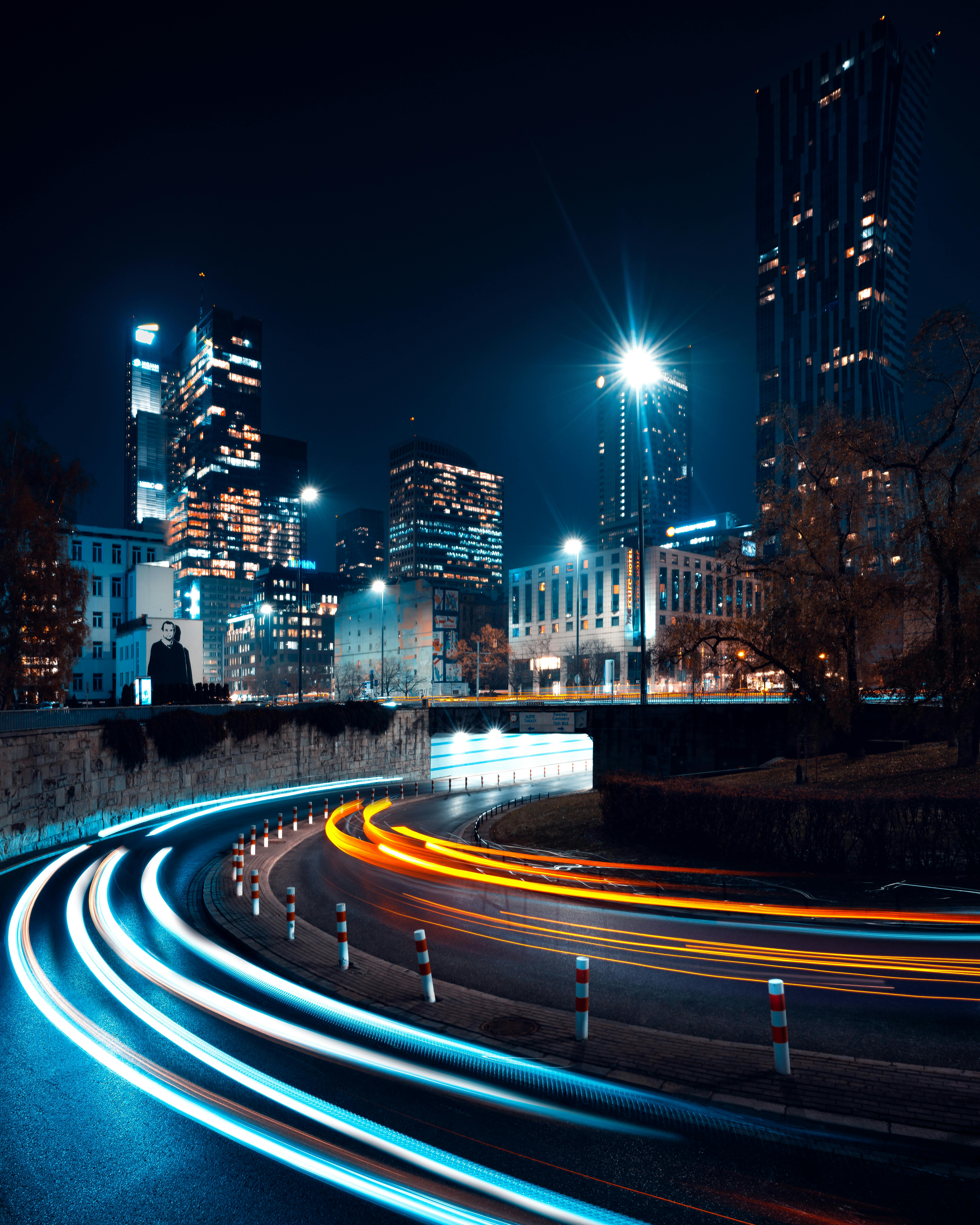 Modern luminous buildings and cars in dark city · Free Stock Photo