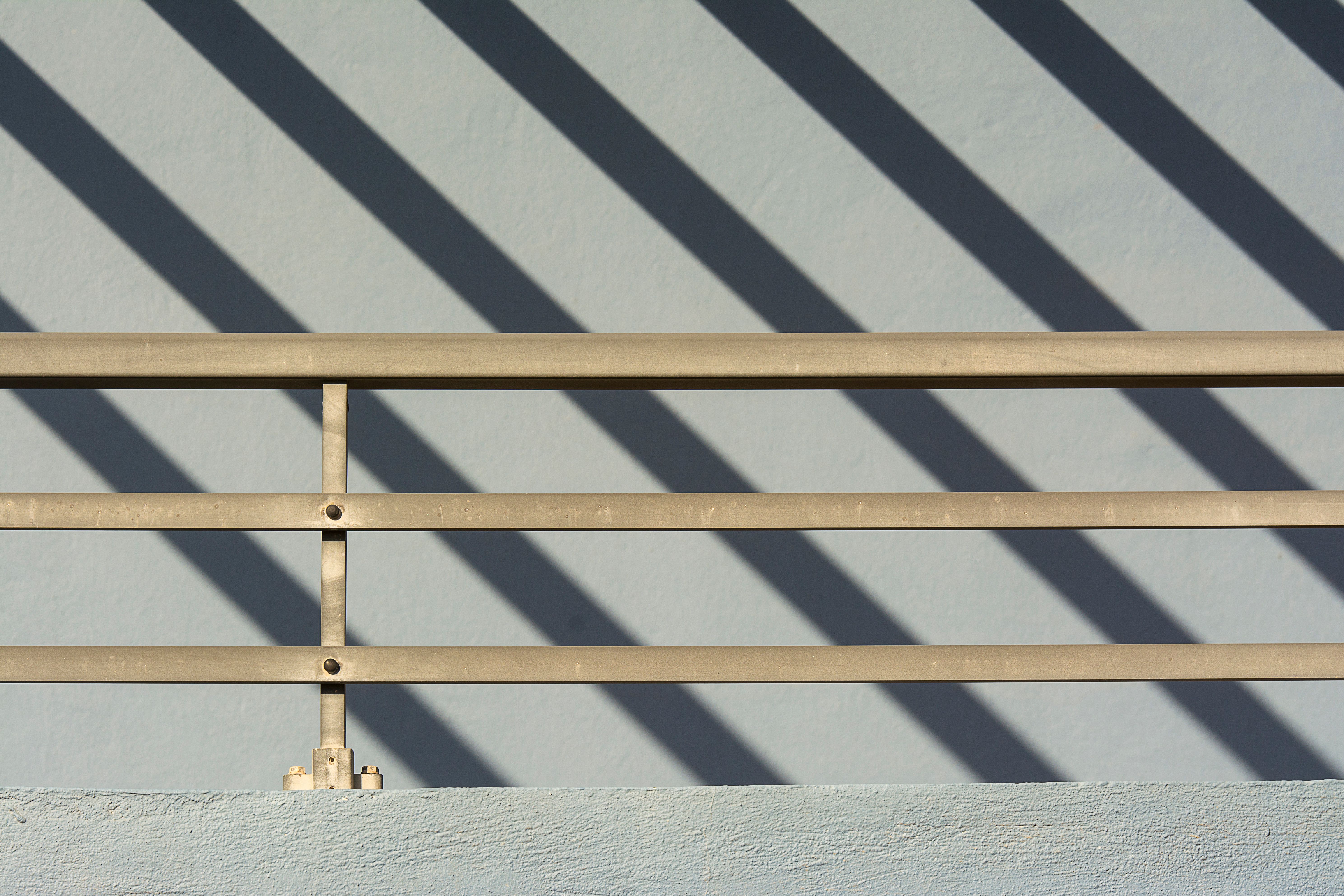 Metal Railing and a Shadow Forming Stripes on the Ground · Free Stock Photo