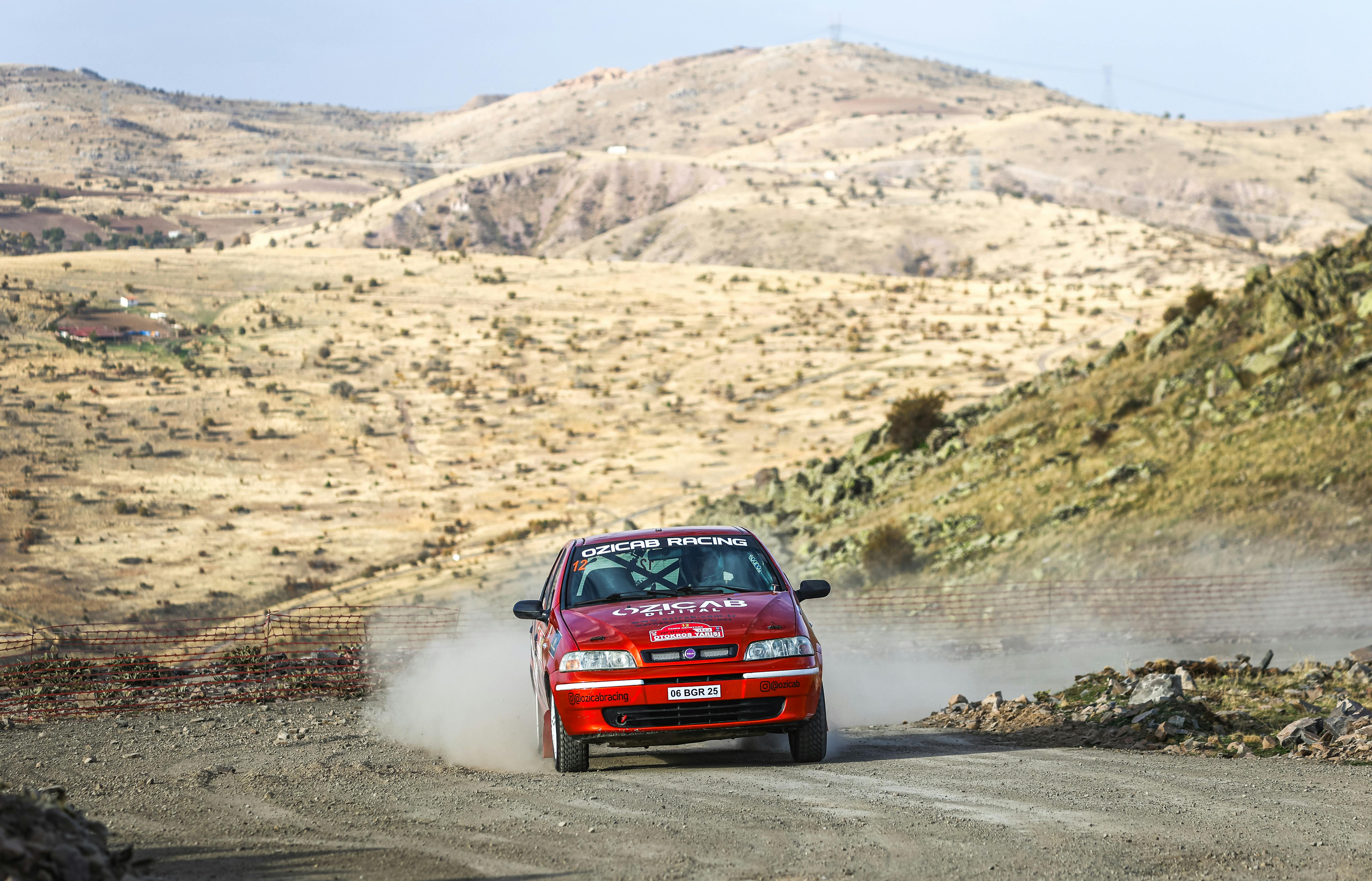 A car driving down a dirt road in the desert · Free Stock Photo