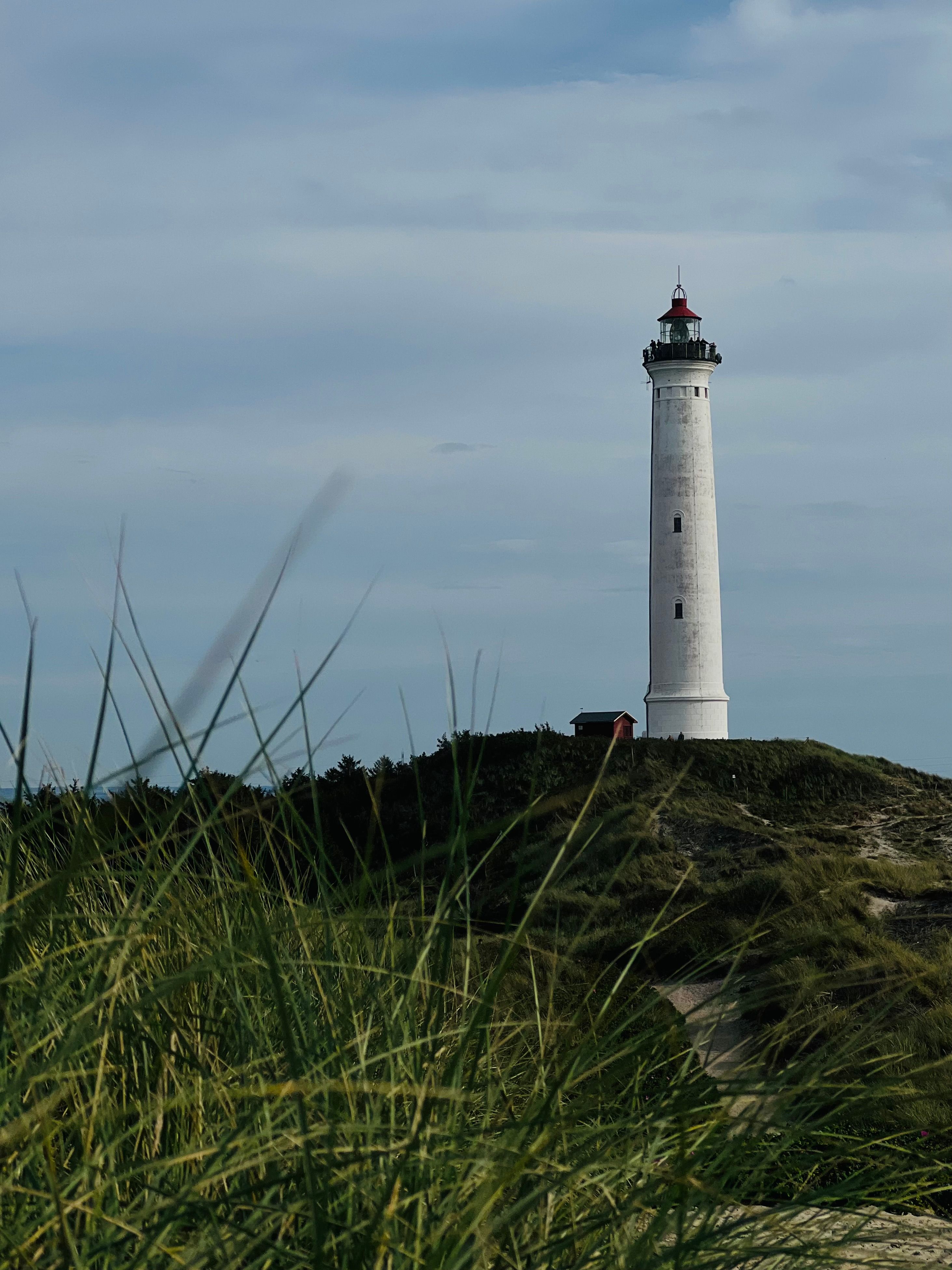 Lighthouse on Grassy Hill · Free Stock Photo