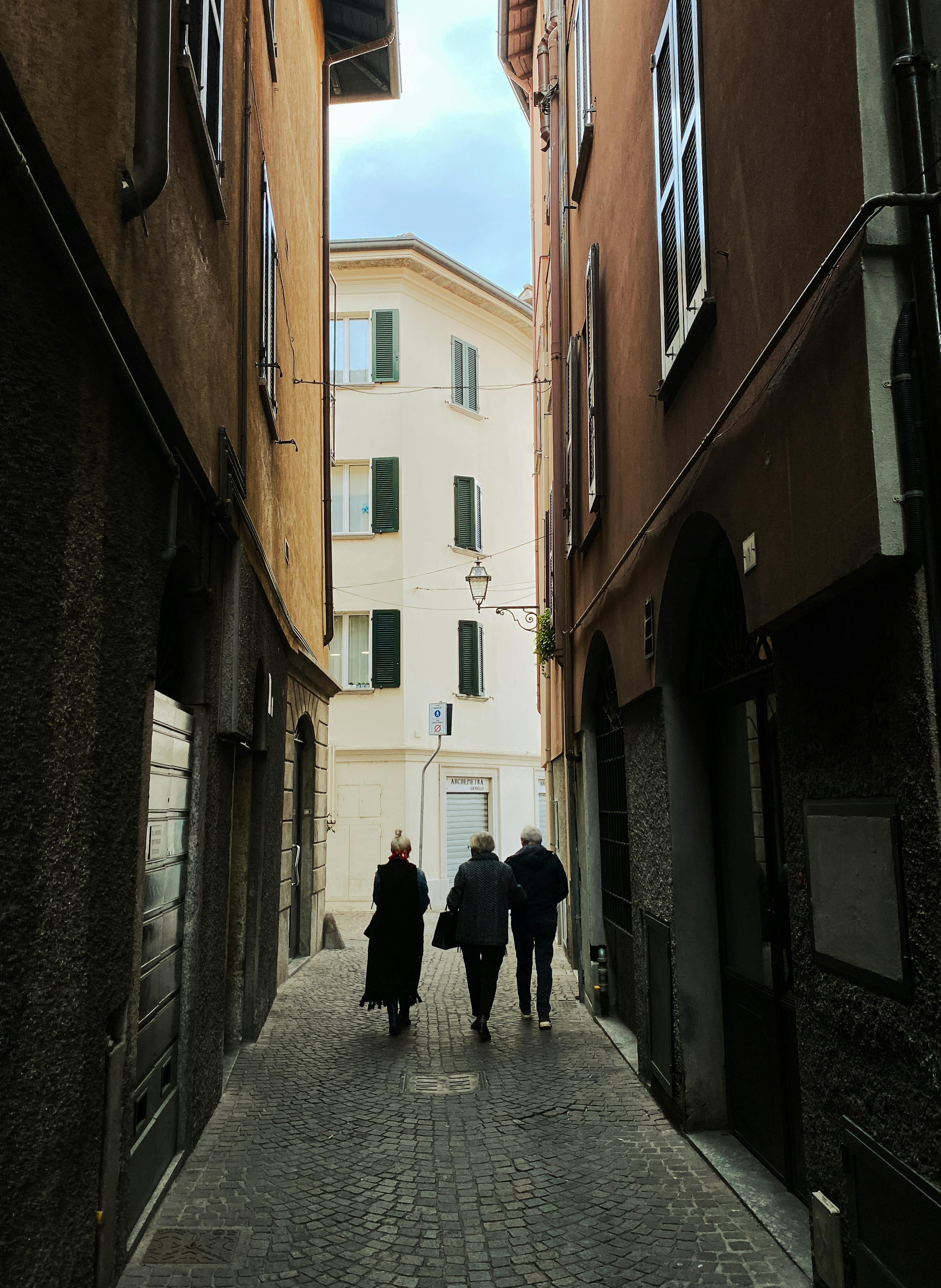 Pedestrians Walking in a Narrow Alley between Residential Buildings in ...