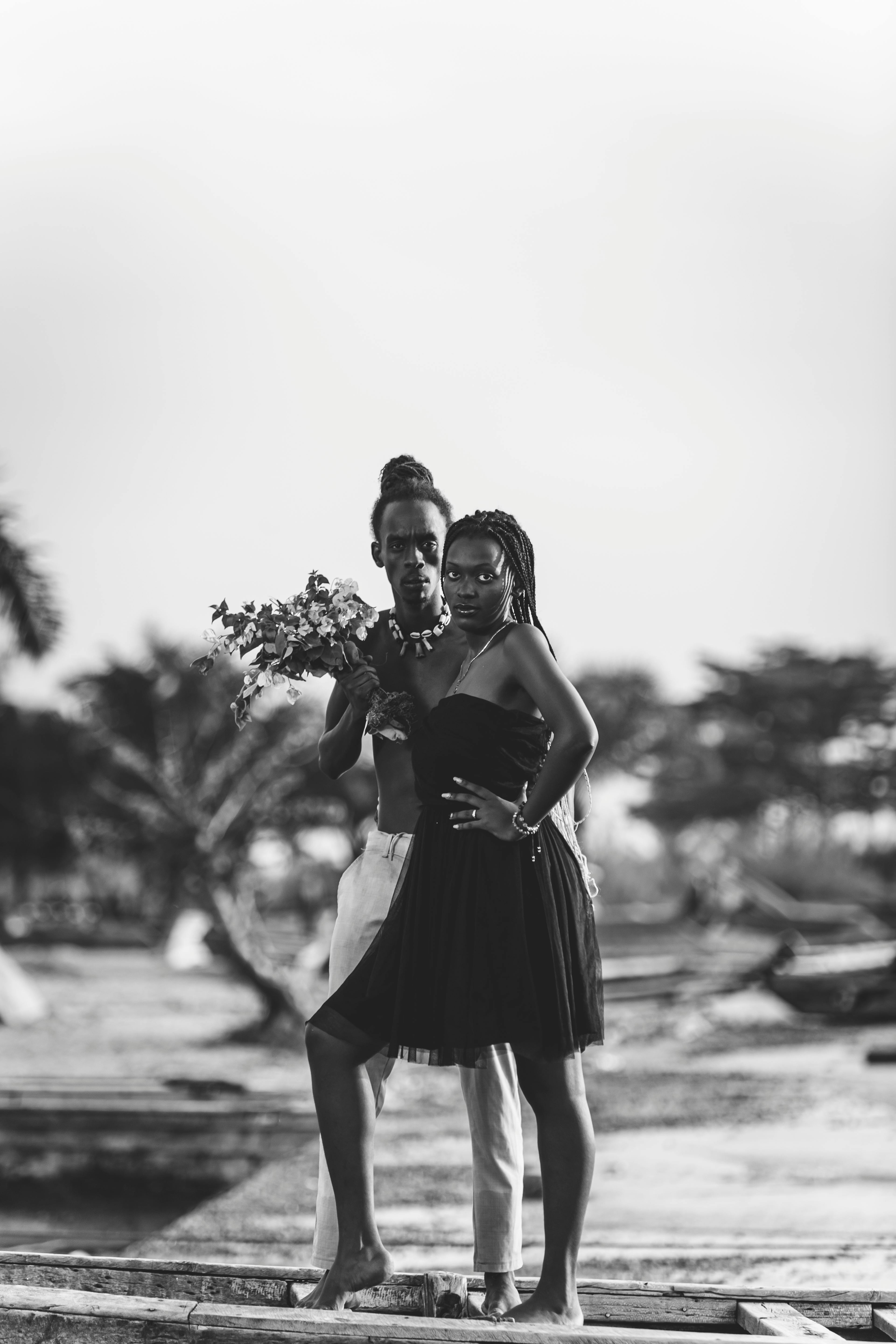 A Man and Woman in a Dress Standing Barefoot Outside · Free Stock Photo