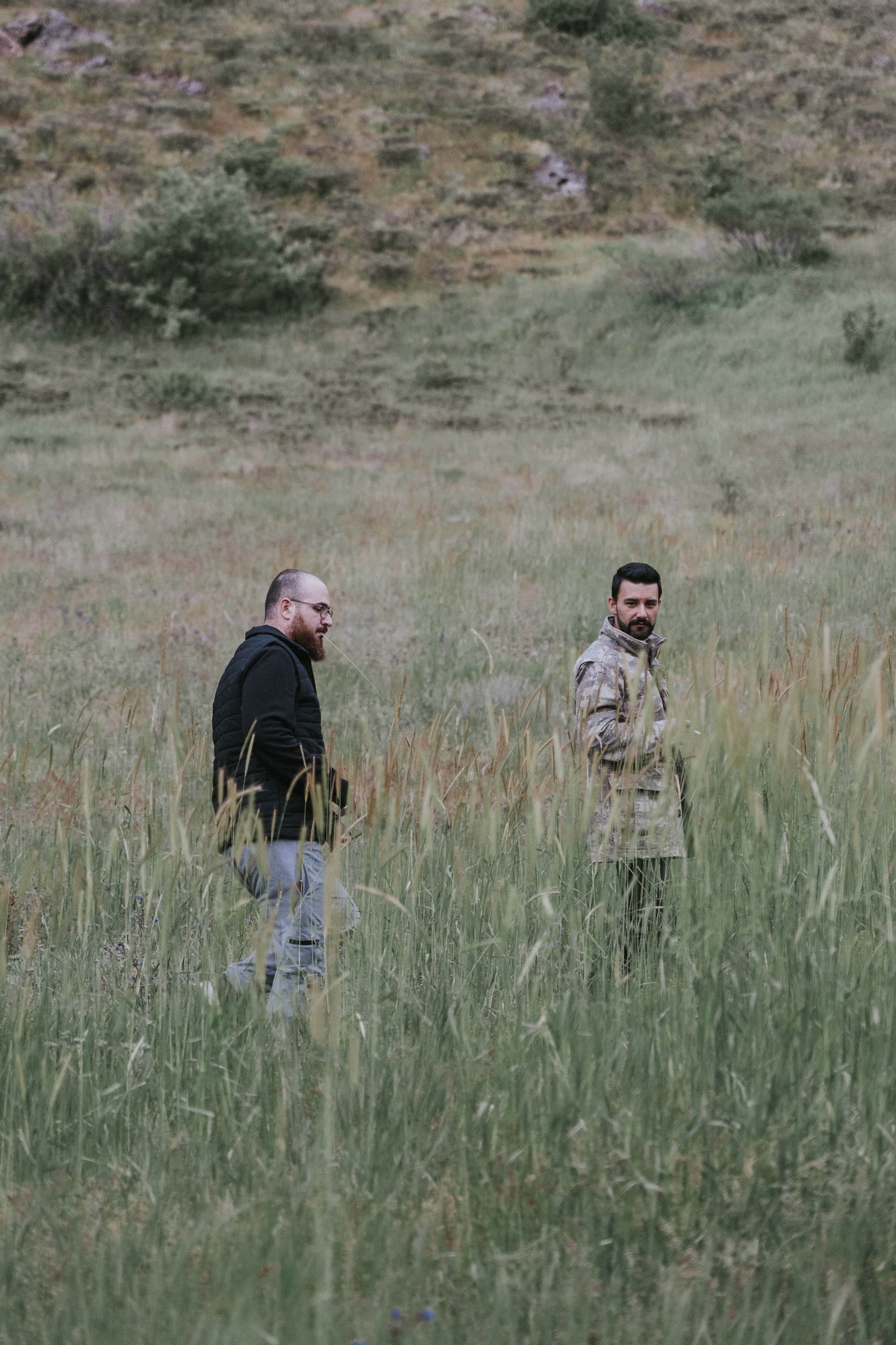 Men Walking Through Meadow · Free Stock Photo