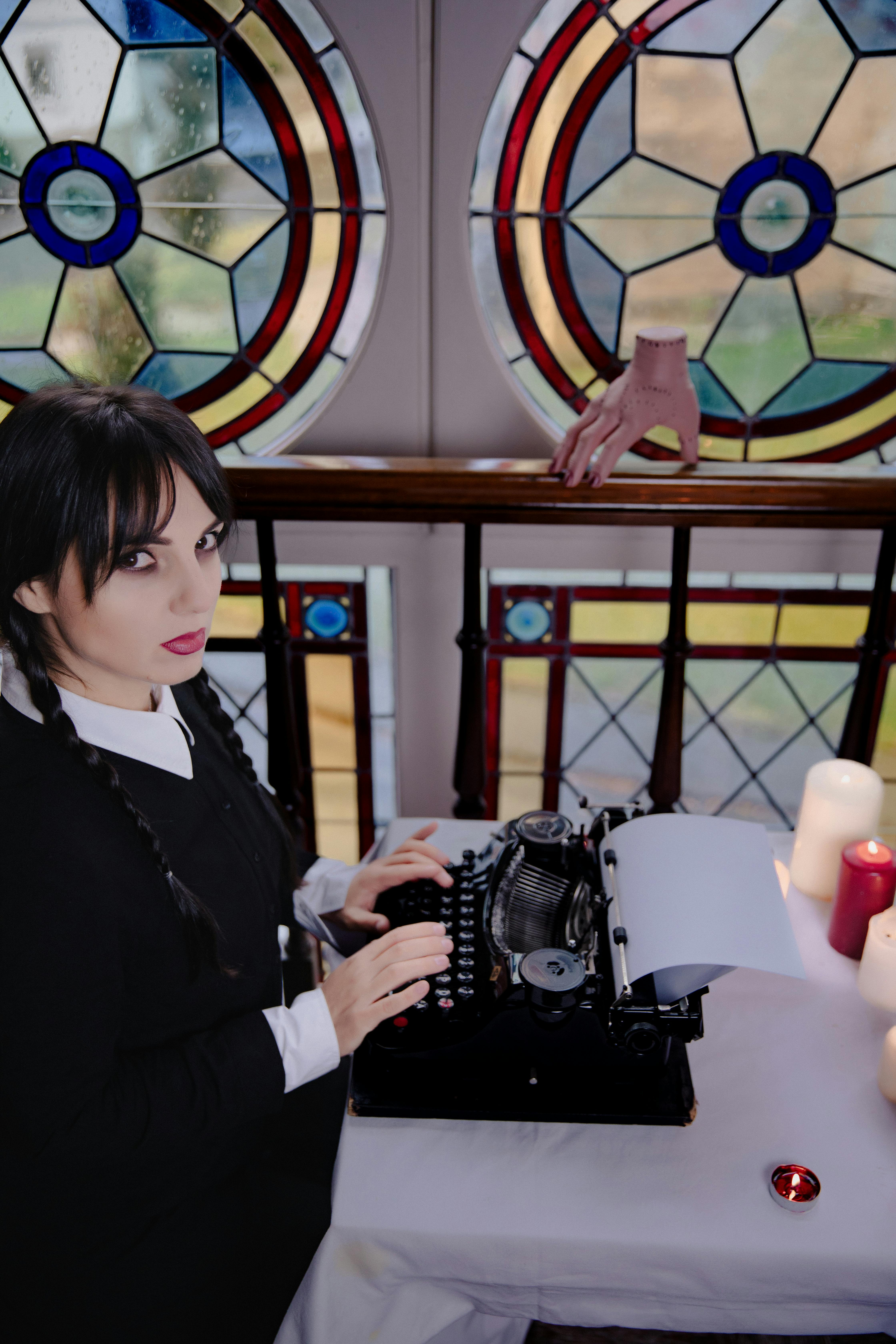 Girl in the Wednesday Addams Costume Writing on a Typewriter · Free ...