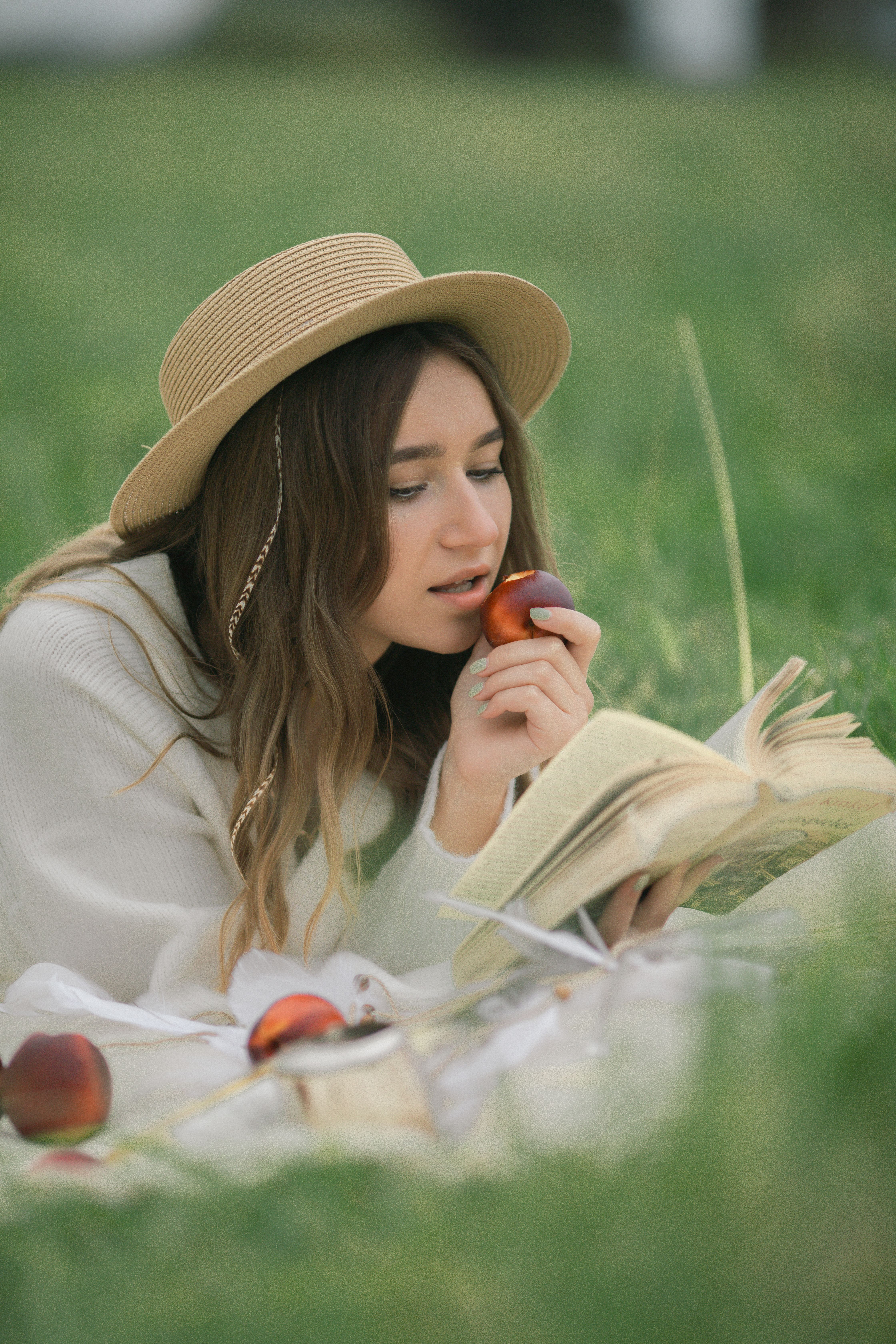 Young Woman Eating Peach and Reading Book · Free Stock Photo