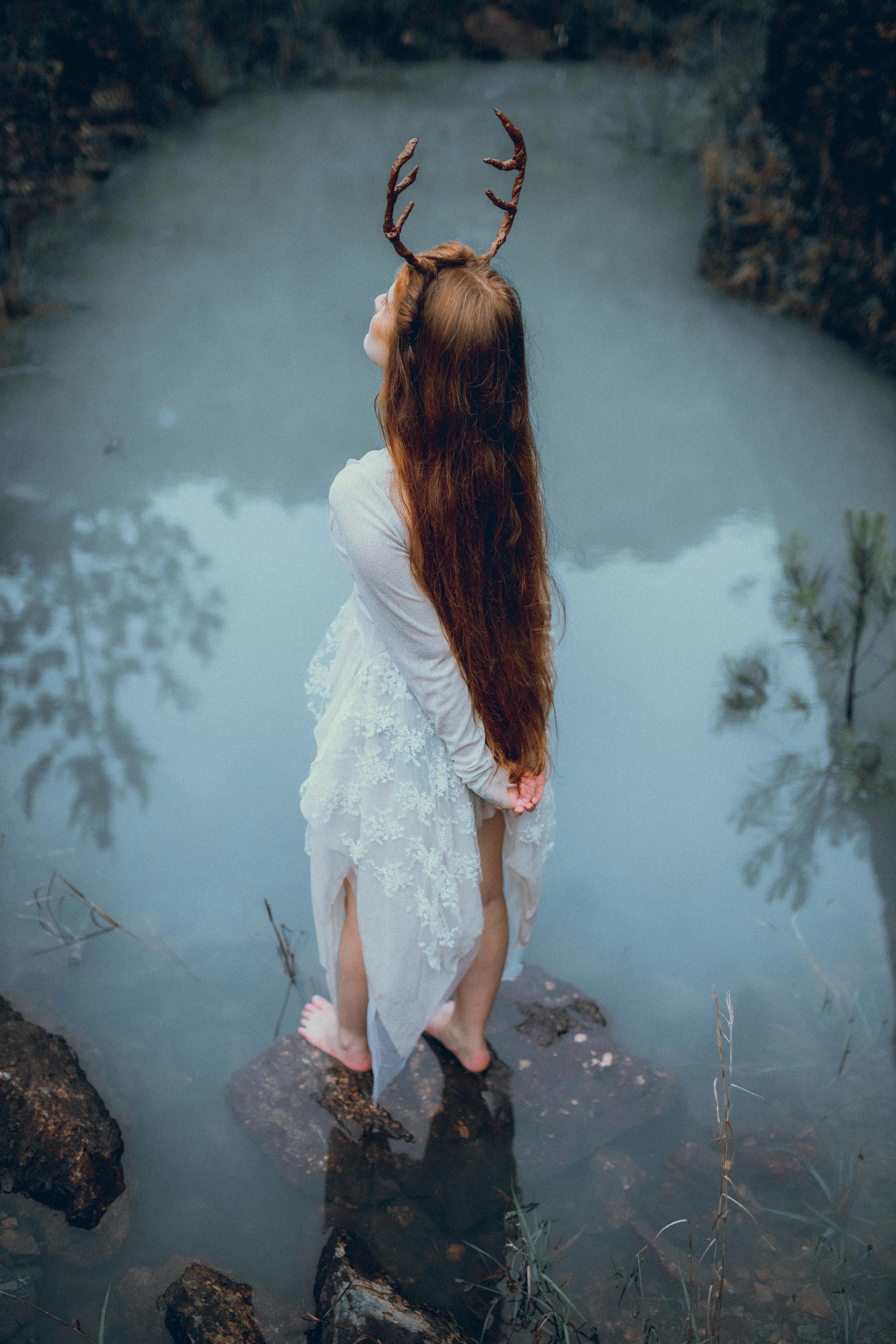 Woman in Red String Spaghetti Strap Dress on Body of Water Near Forest ...