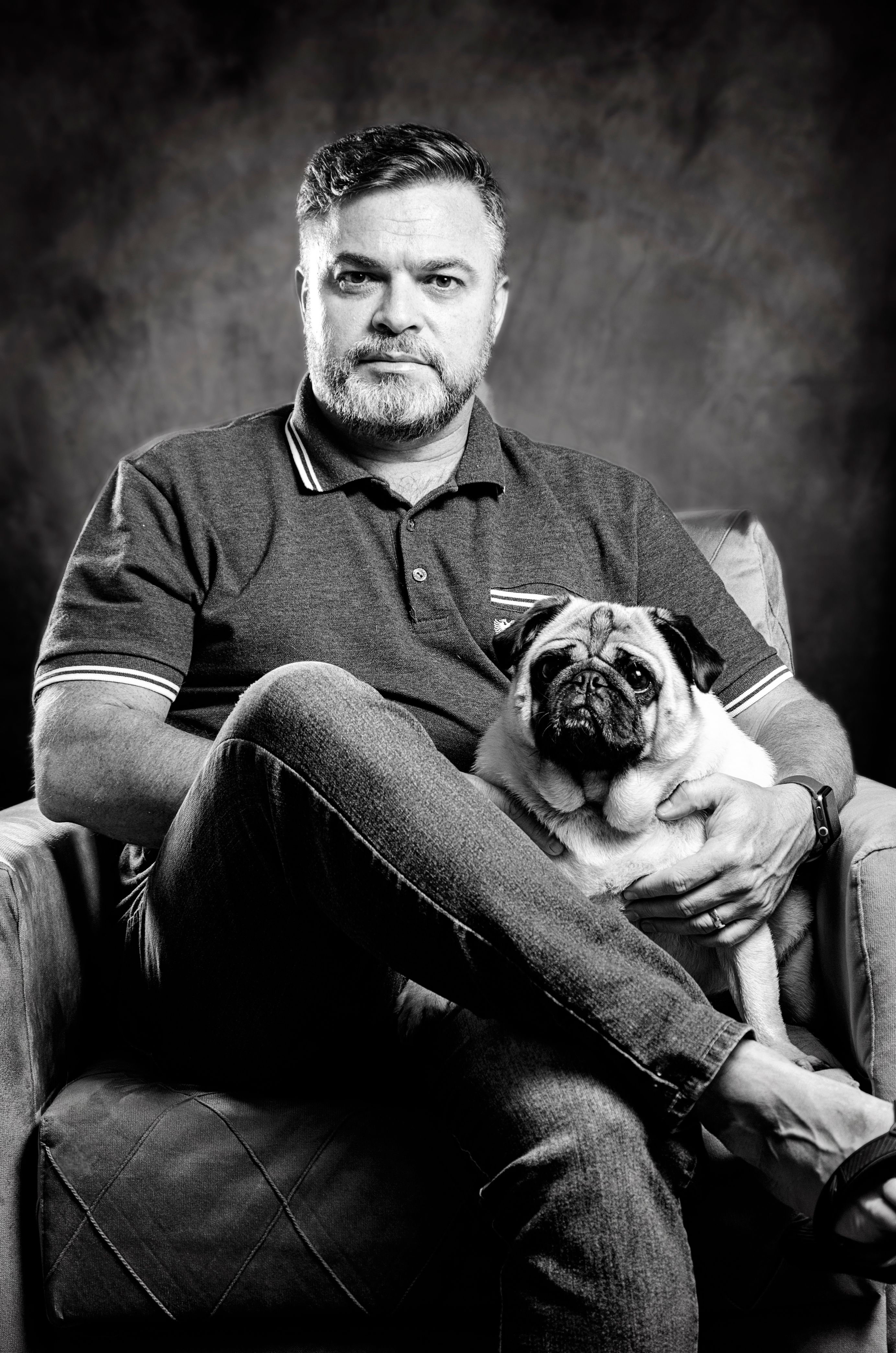 Portrait of a Man Sitting in an Armchair with a Pug Dog · Free Stock Photo