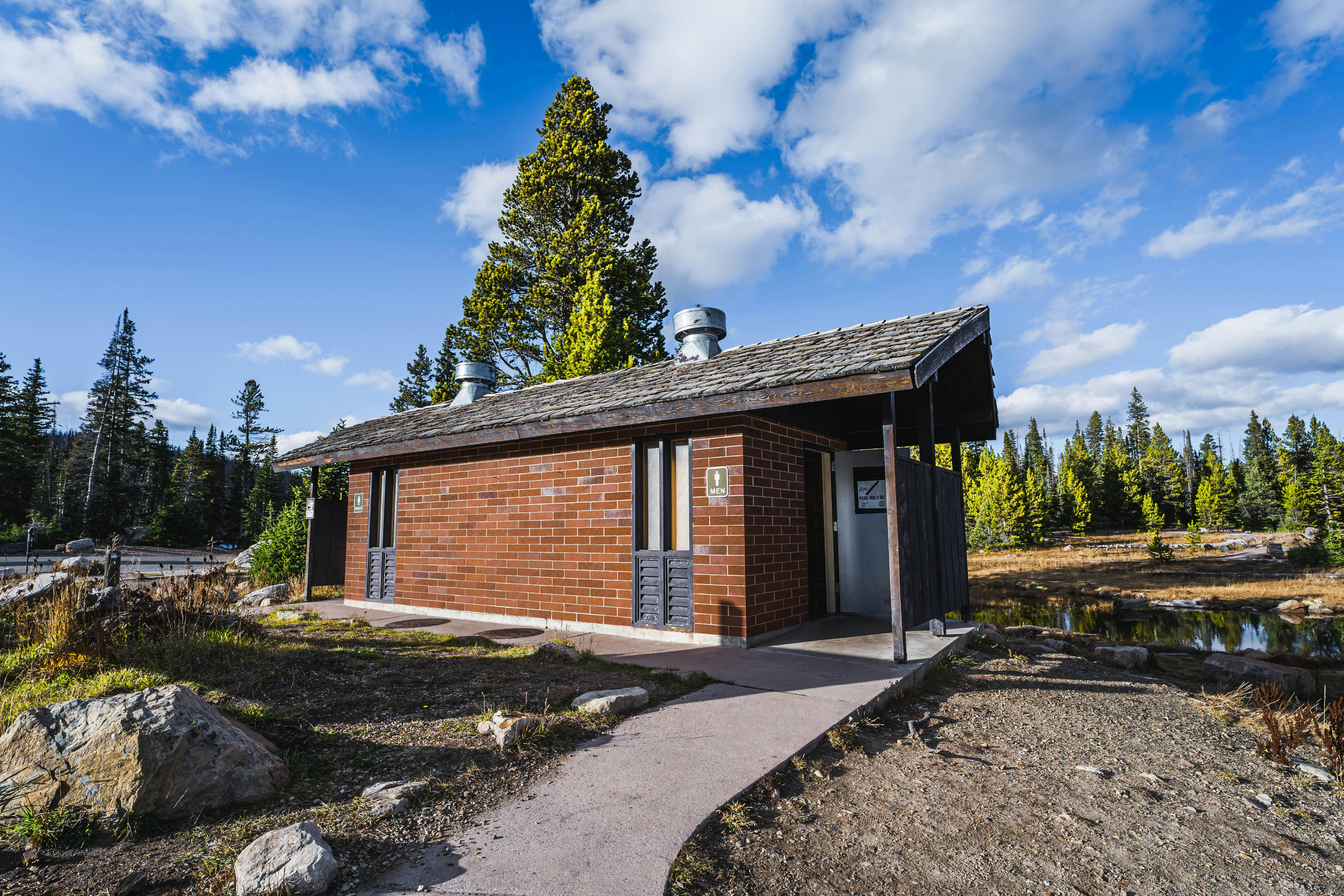 Brick Hut Among Coniferous Forest · Free Stock Photo