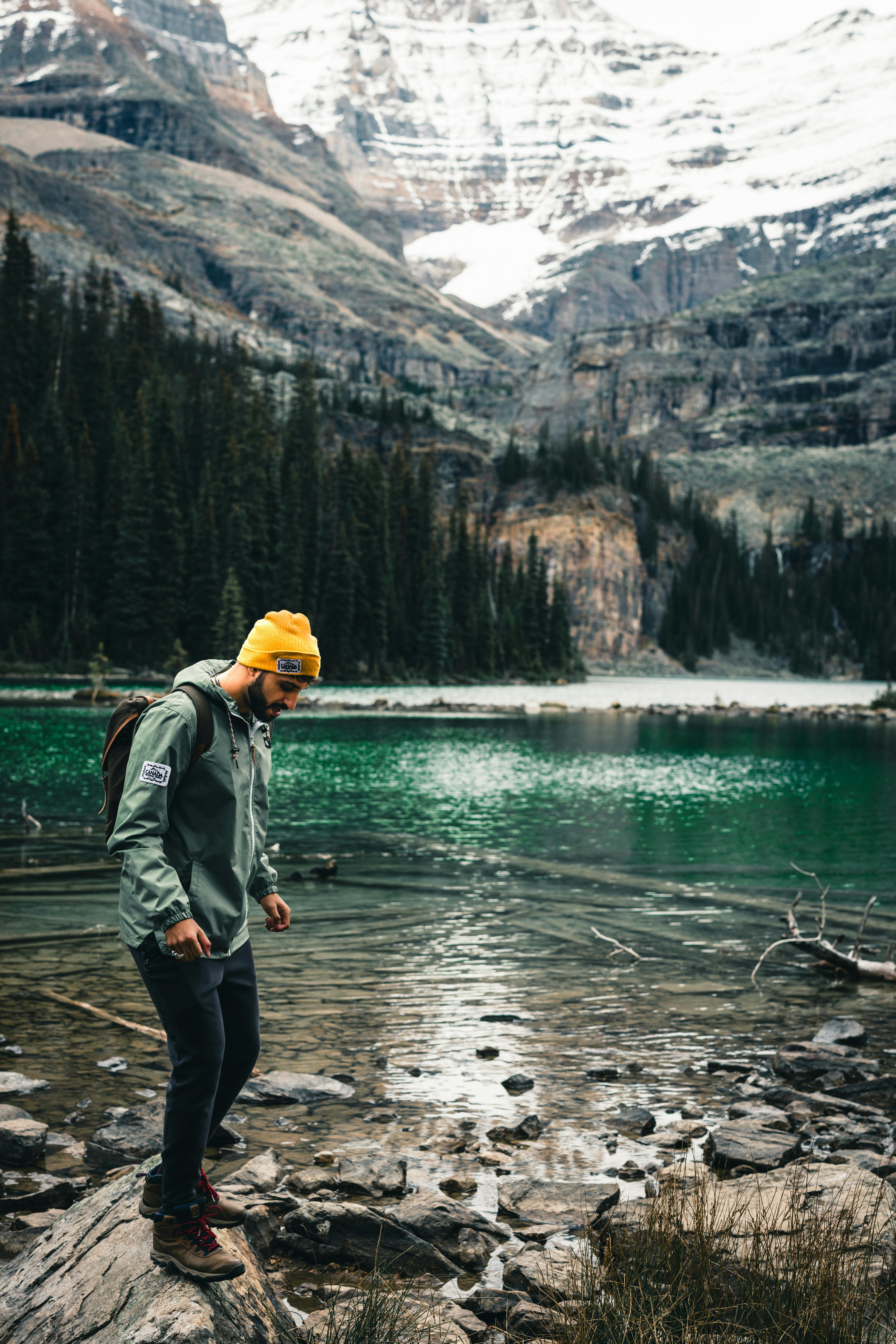 Man Standing by Lake in Mountains · Free Stock Photo