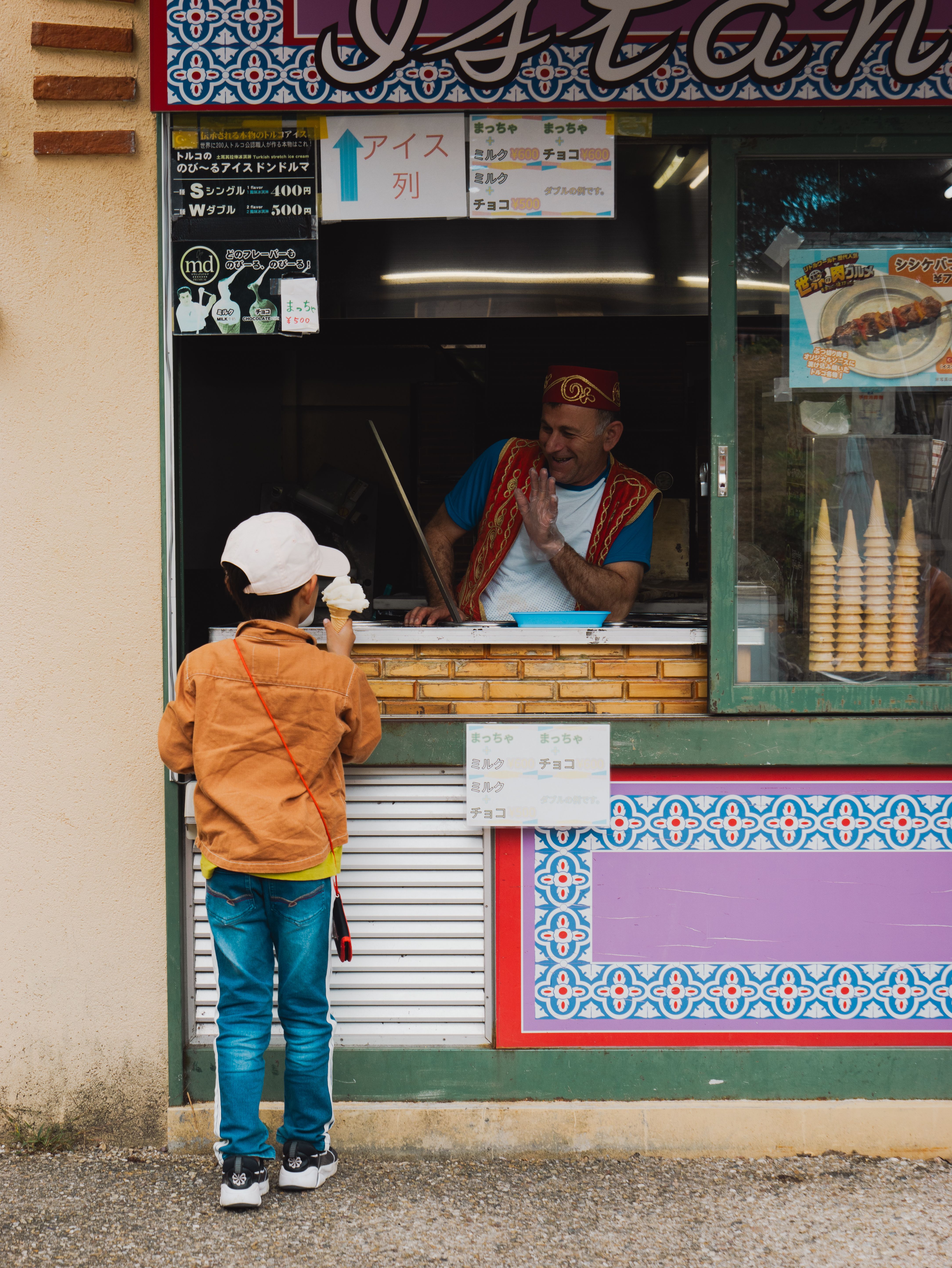 A Little Boy Buying Ice Cream in a Booth · Free Stock Photo