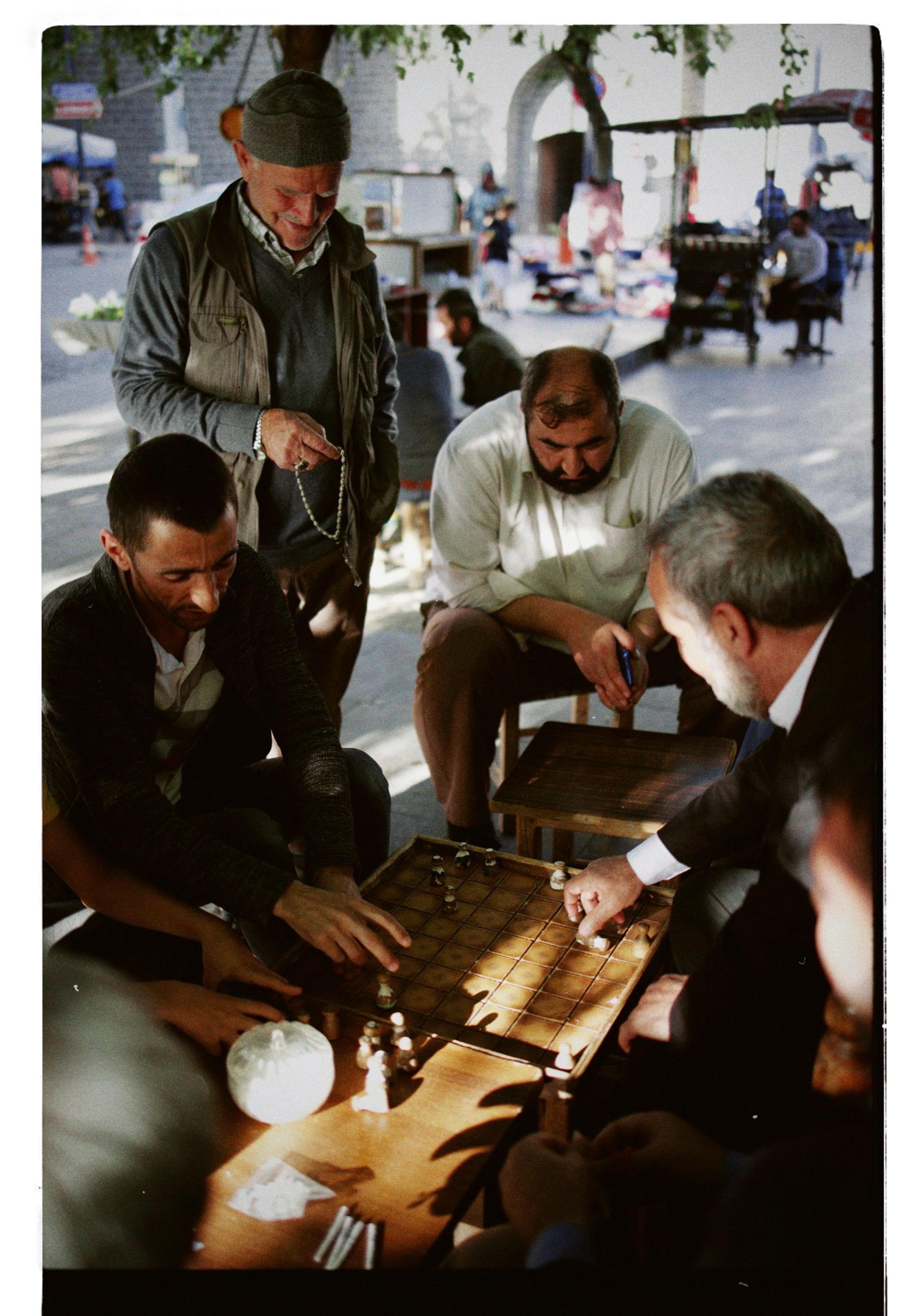 Men Playing and Observing the Game of Checkers in City Square · Free ...