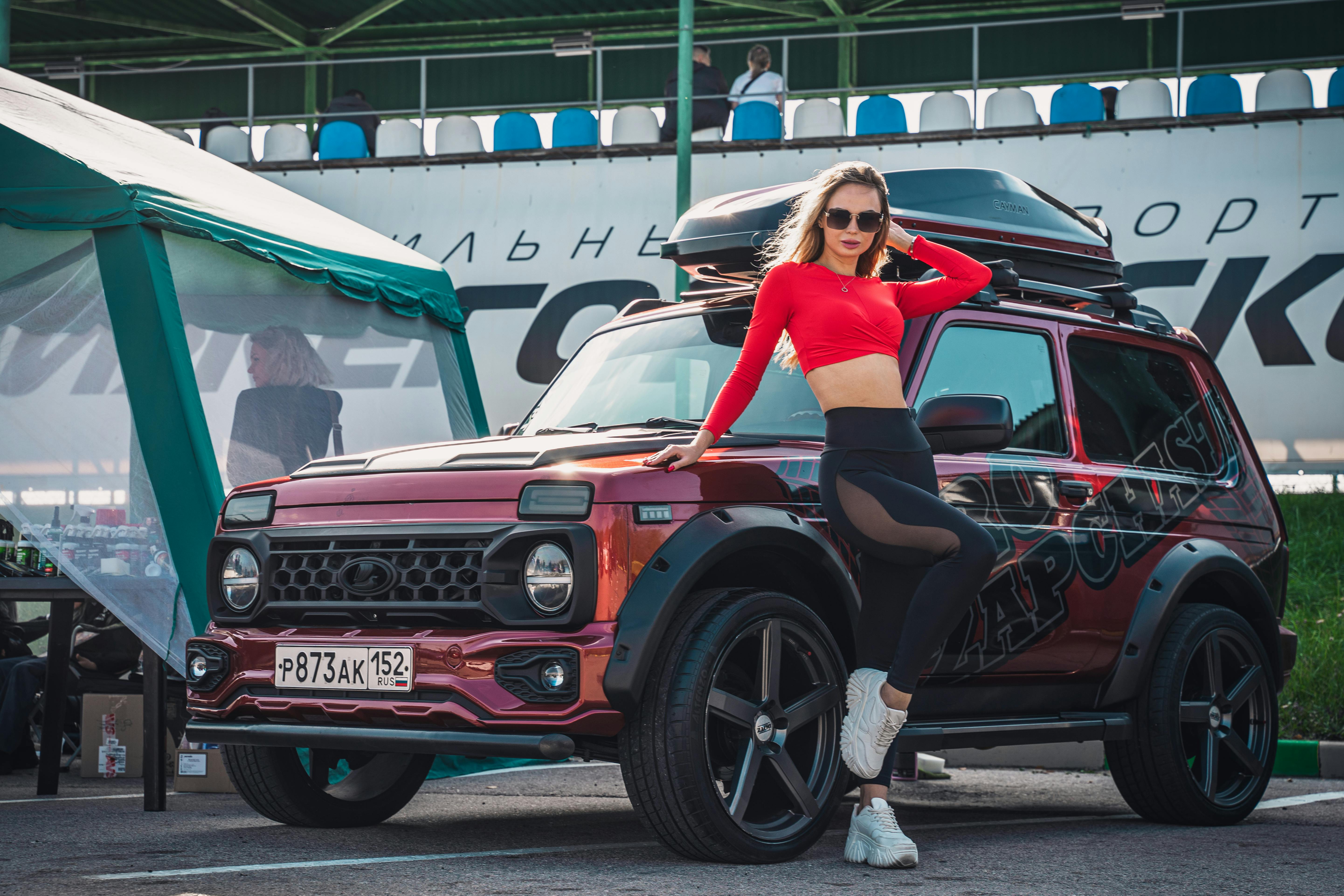 Woman in Red Crop Top and Black Leggings Posing by a Tuned Lada Niva ...