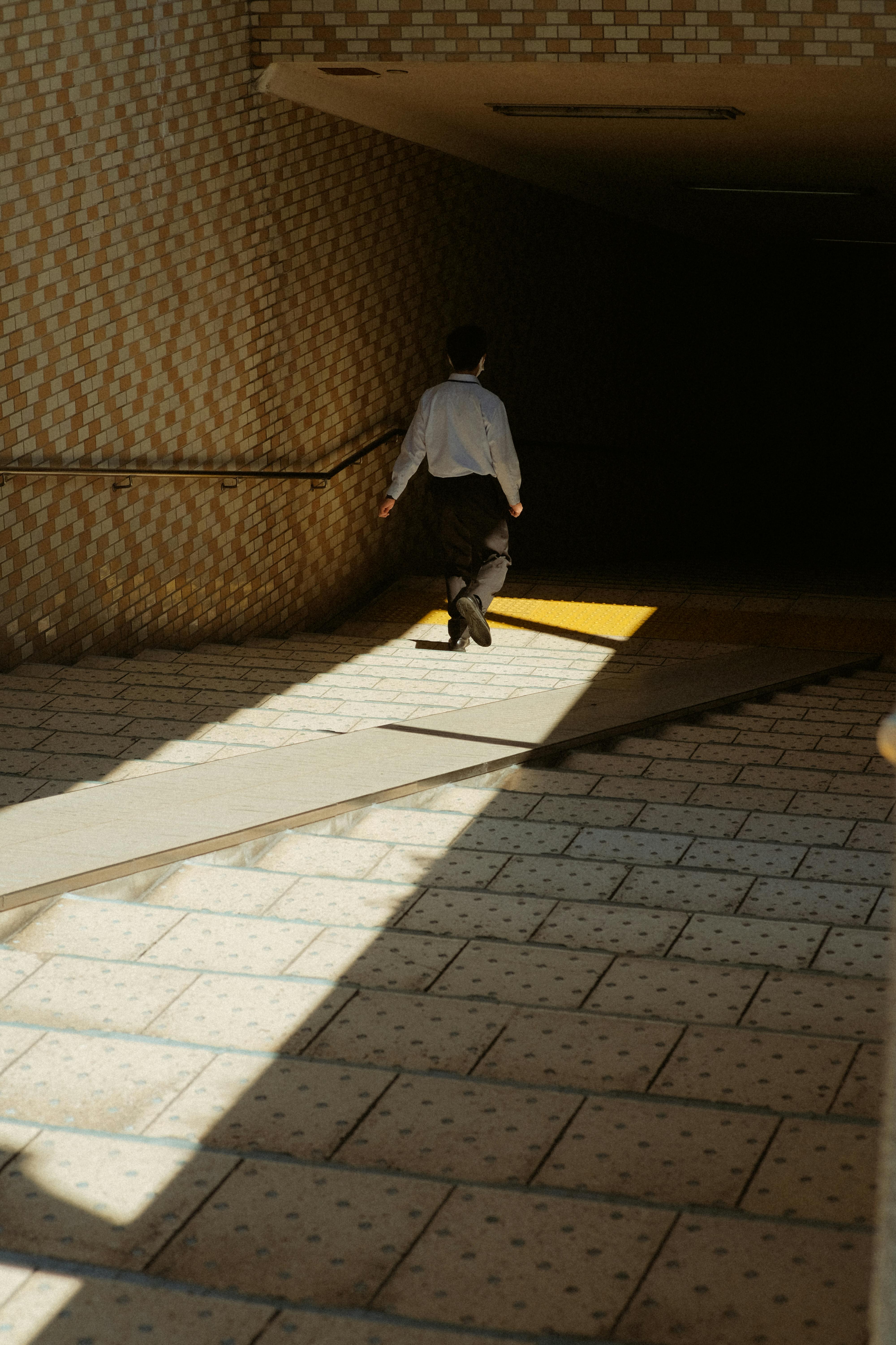 Man Walking Down the Stairs in an Underground Passage · Free Stock Photo