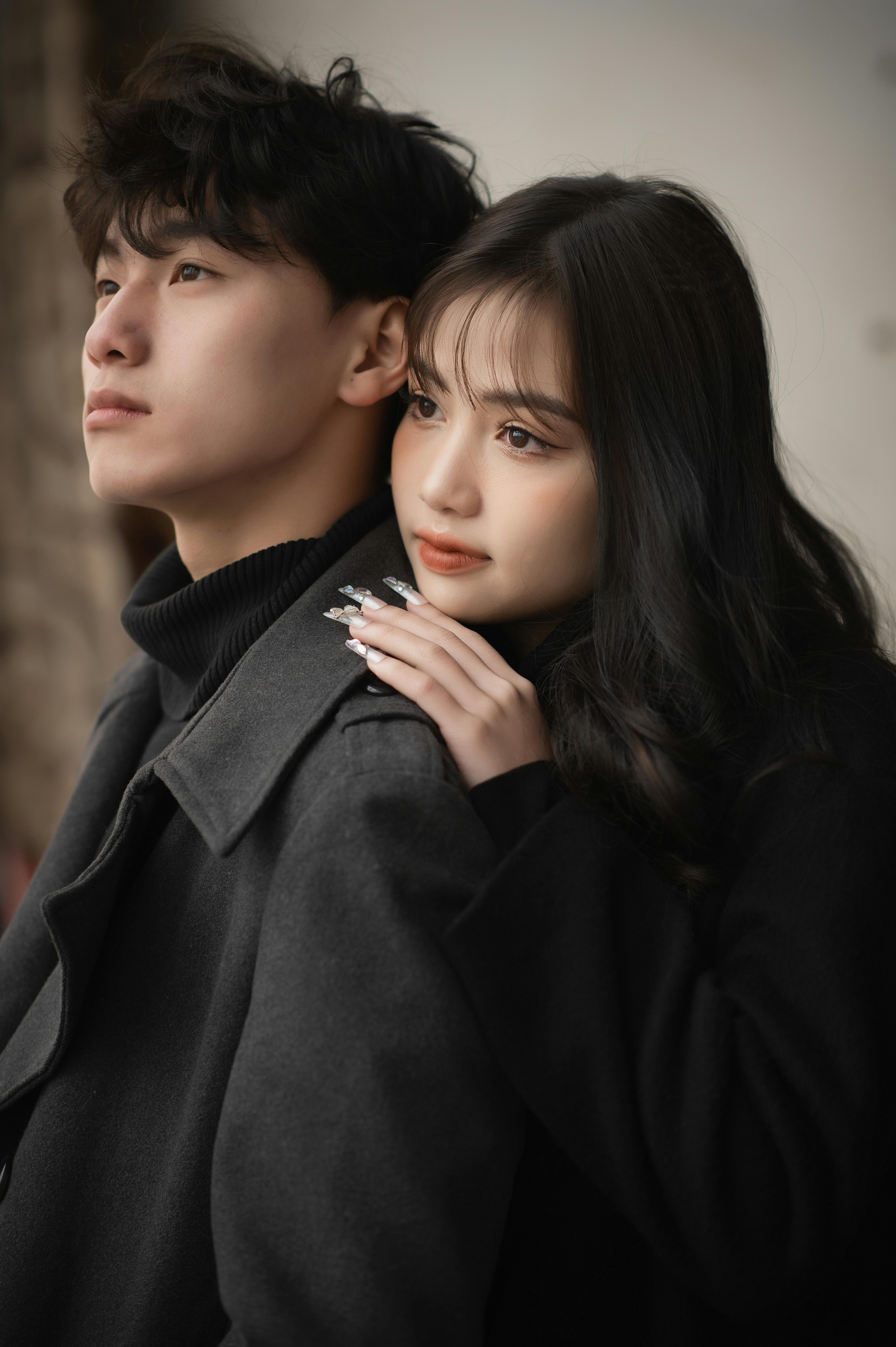 Young Couple Wearing Coats Standing and Hugging · Free Stock Photo