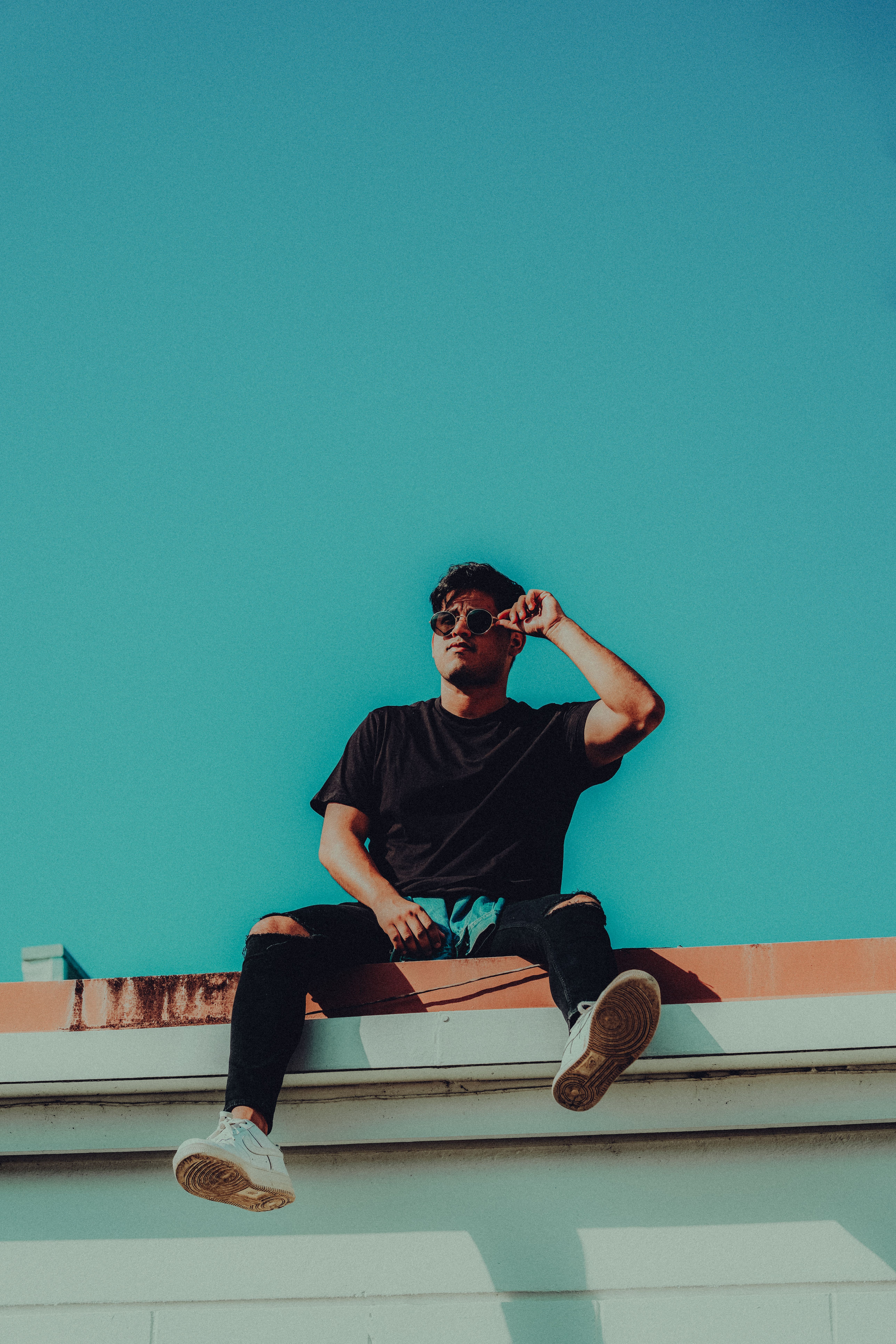 Man Sitting on Building Roof · Free Stock Photo