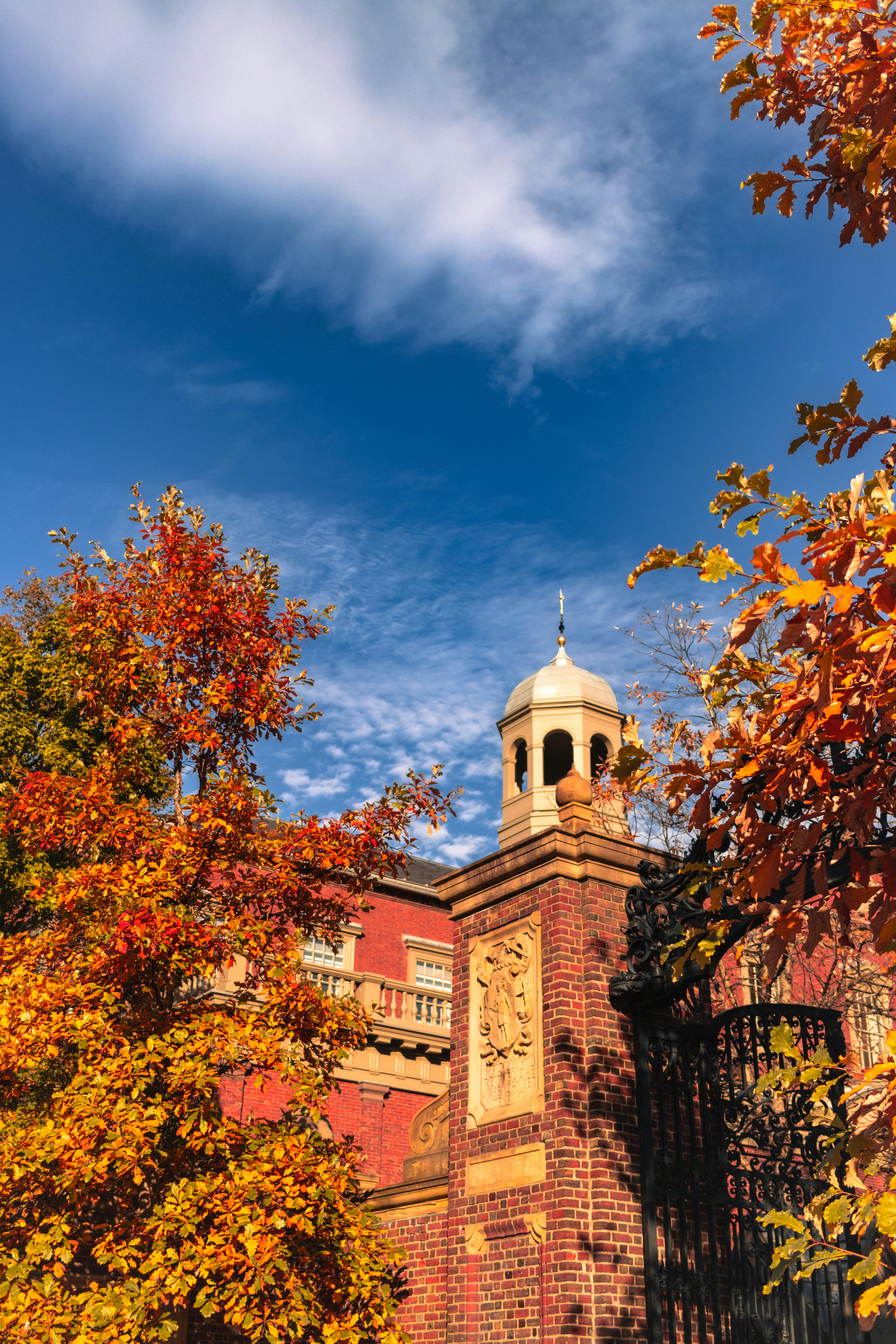 A Gate and Tower of a Historical Building and View of Autumnal Trees ...