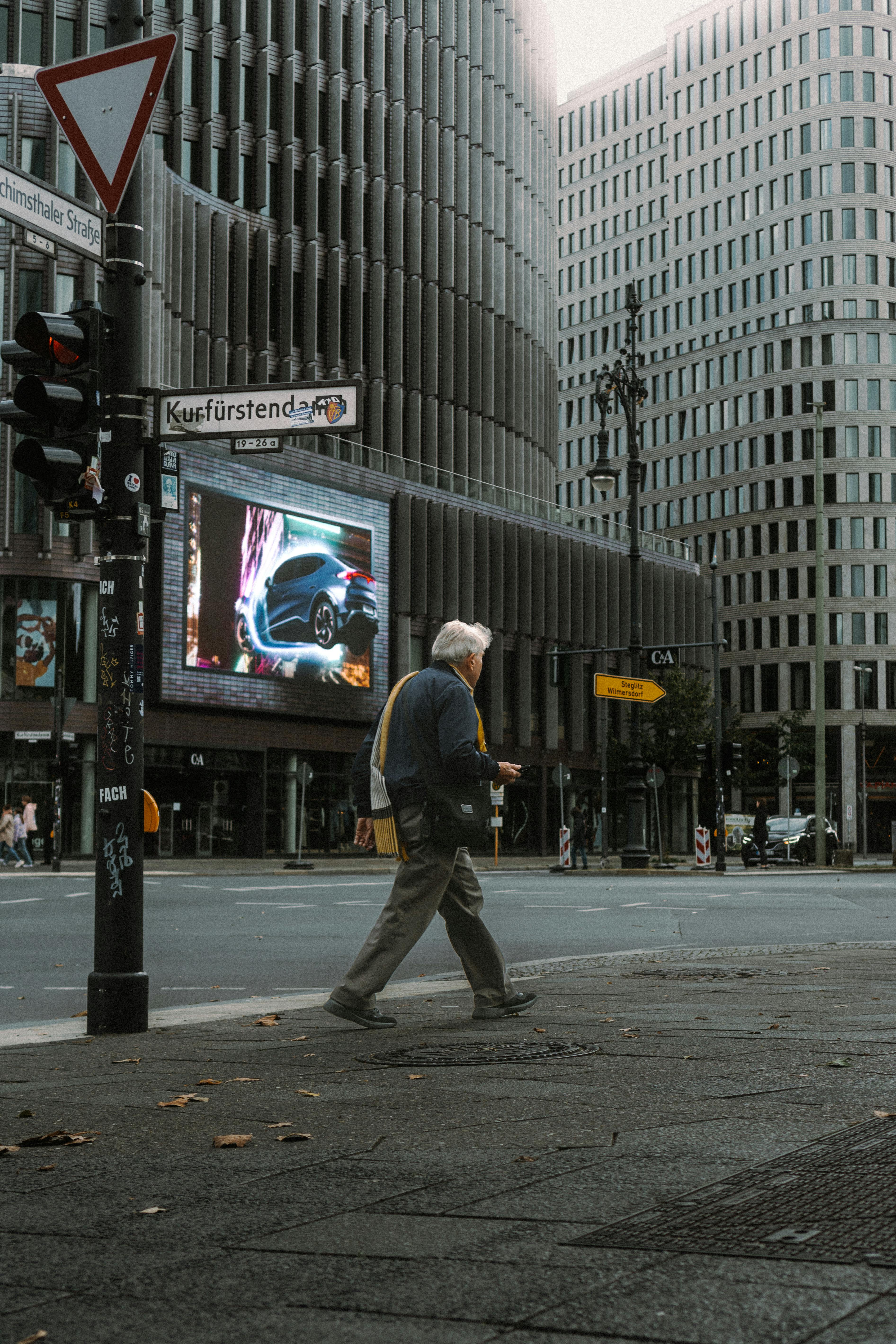 Old man walking near board with posters on street · Free Stock Photo