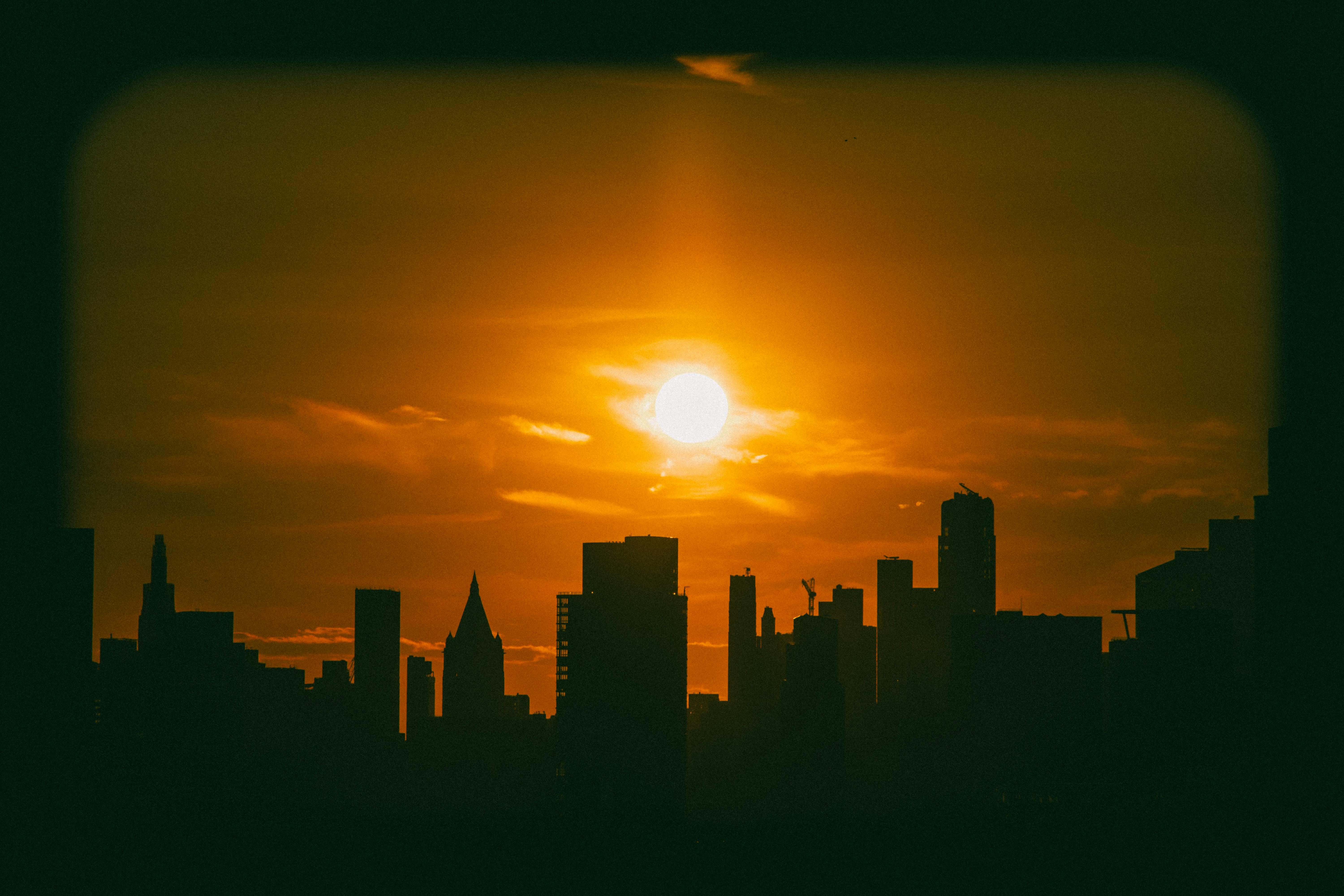 Sun over City Skyscrapers Silhouette behind Window at Sunset · Free ...