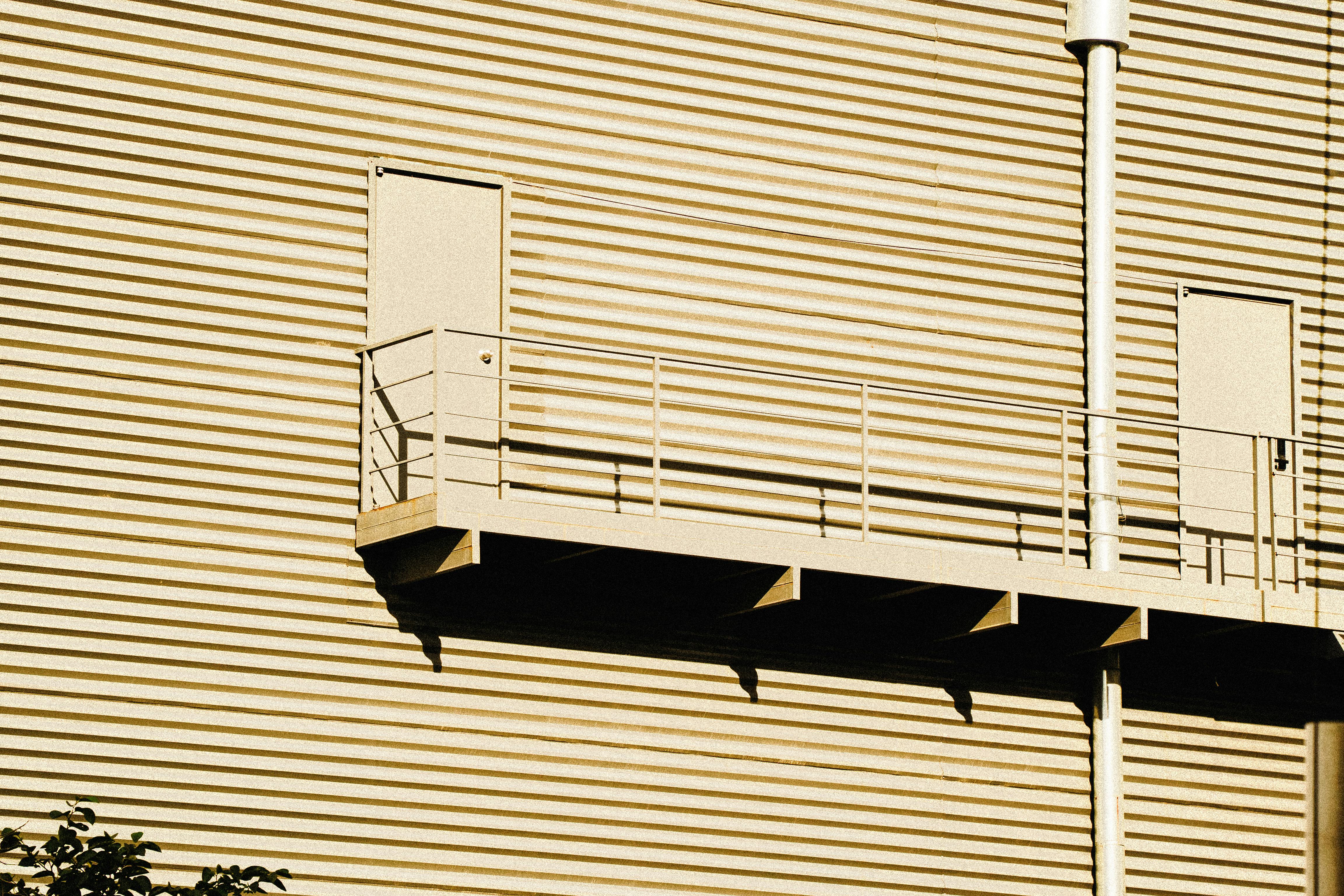Beige Exterior of a Building with Two Doors and a Balcony · Free Stock Photo