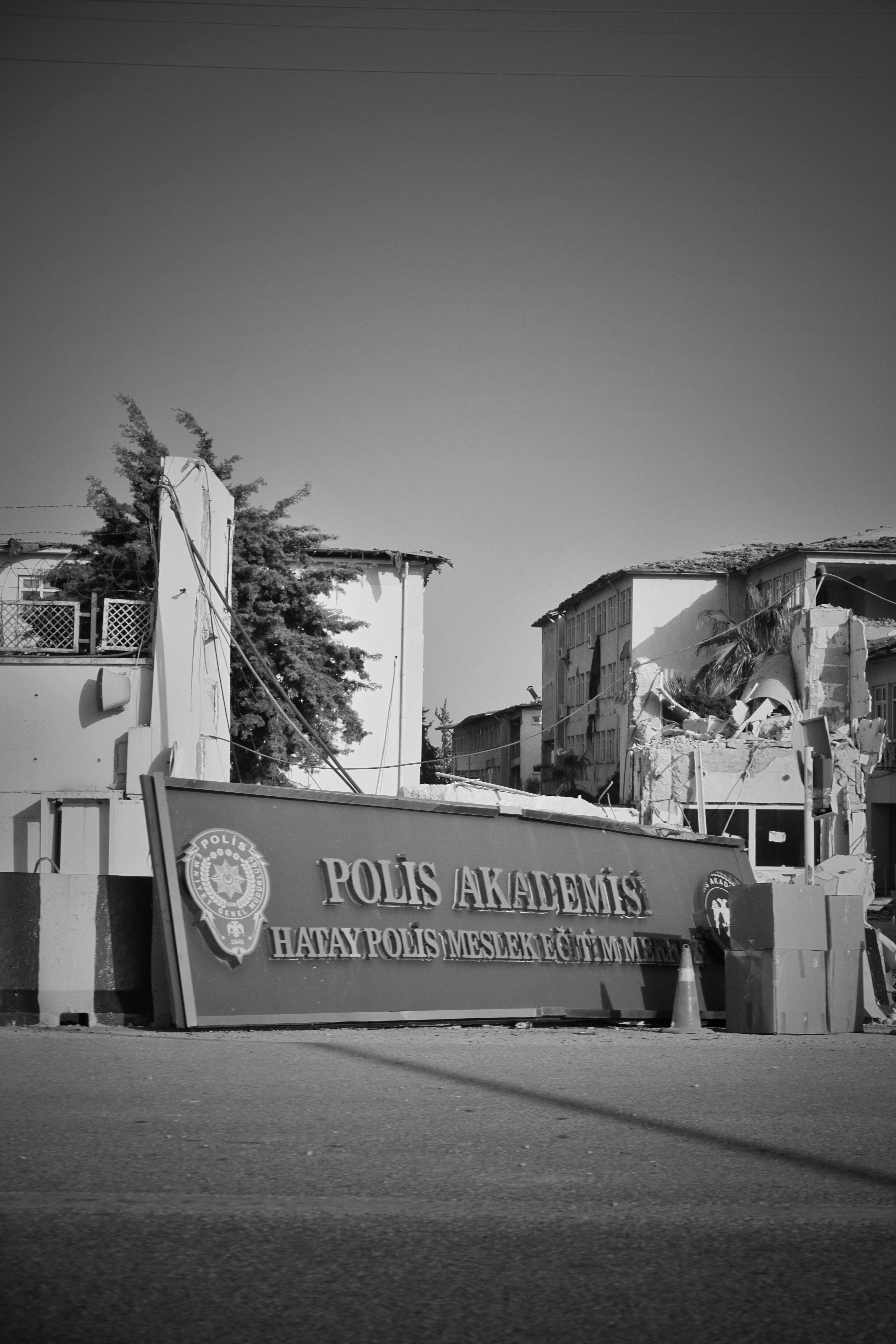 Hatay Police Academy Sign Lying on a Road near Damaged Building, Turkey ...