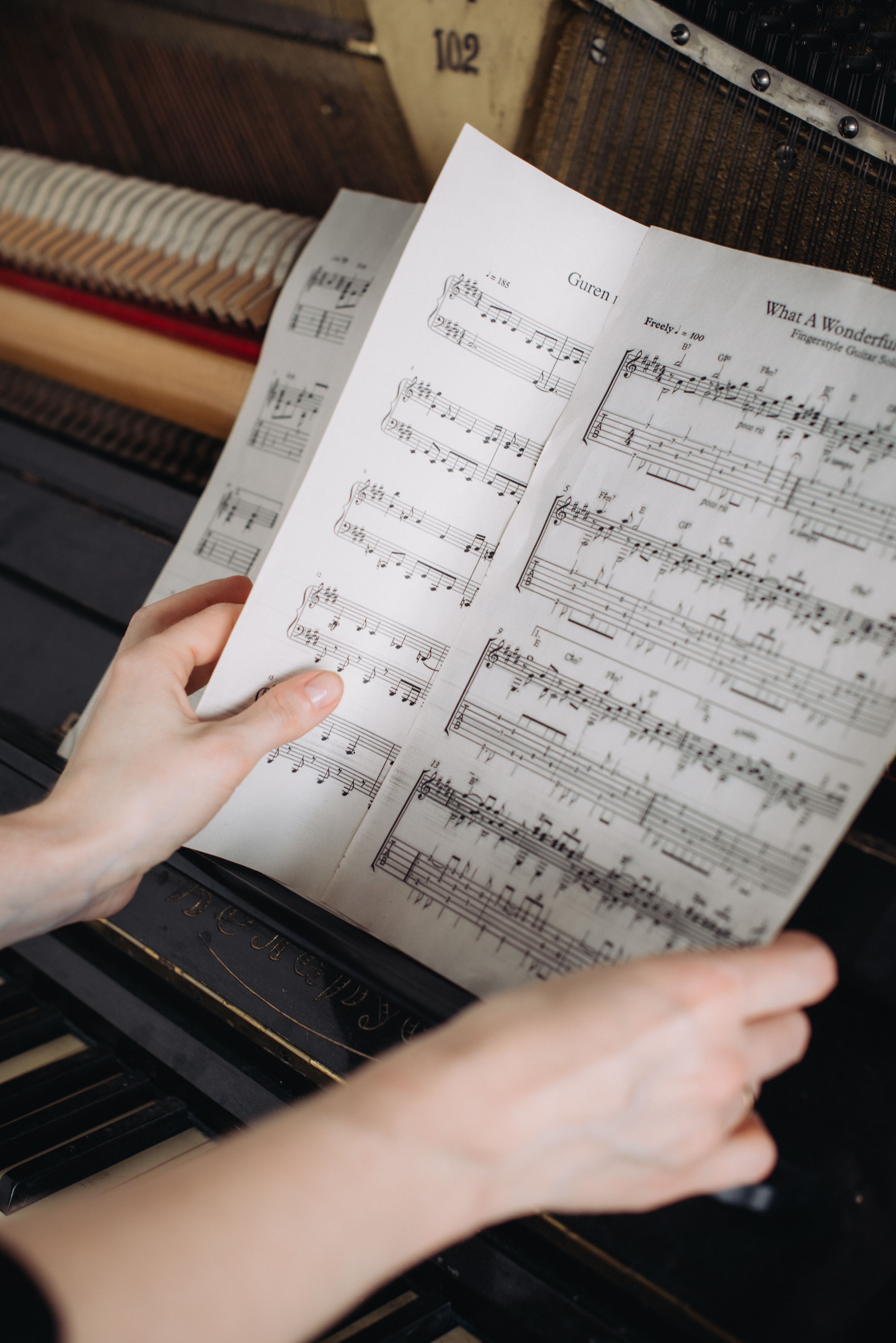 Woman Turning Pages of Sheet Music at a Piano · Free Stock Photo