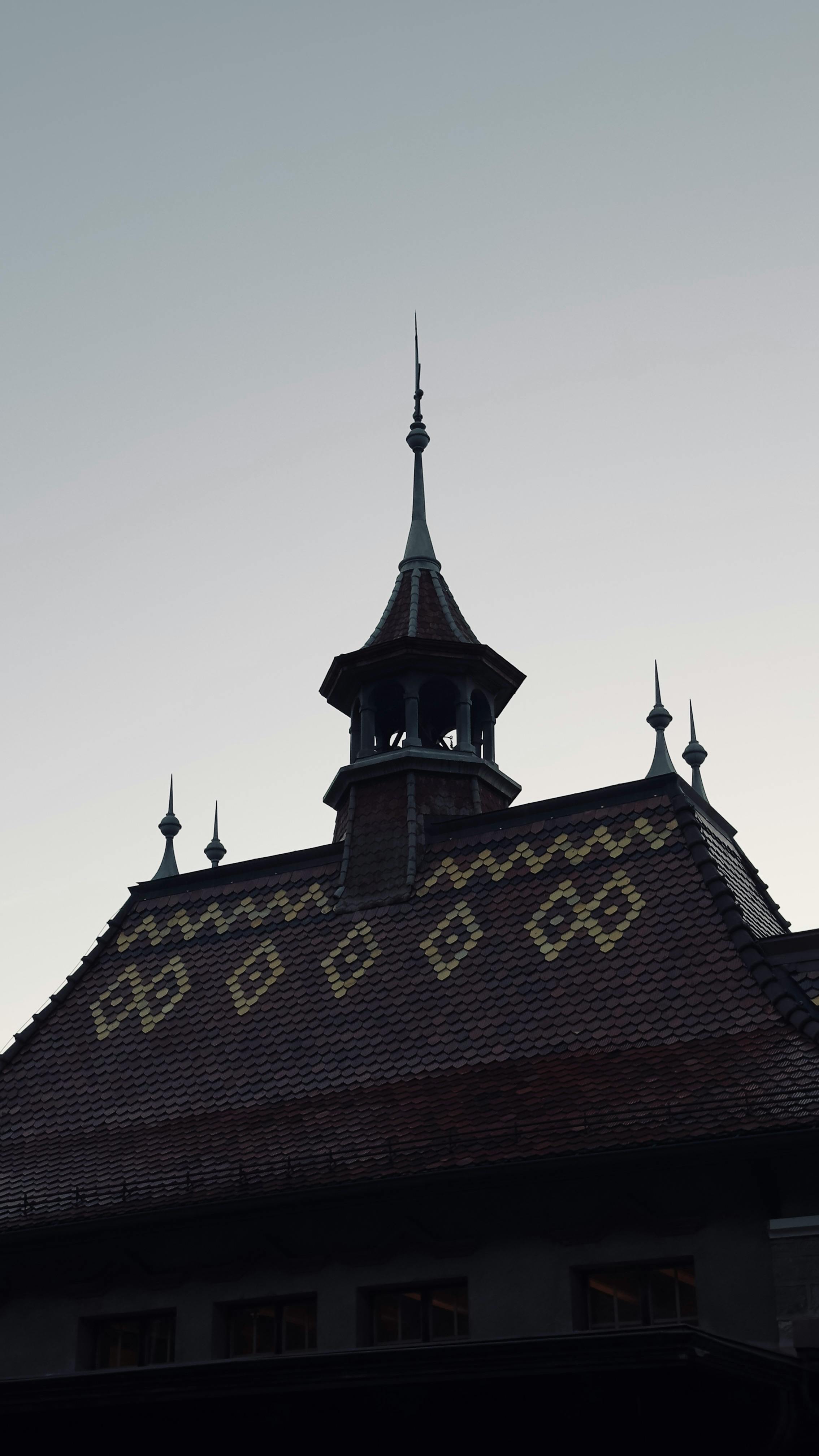 Facade of a Building with a Patterned Roof and a Tower · Free Stock Photo