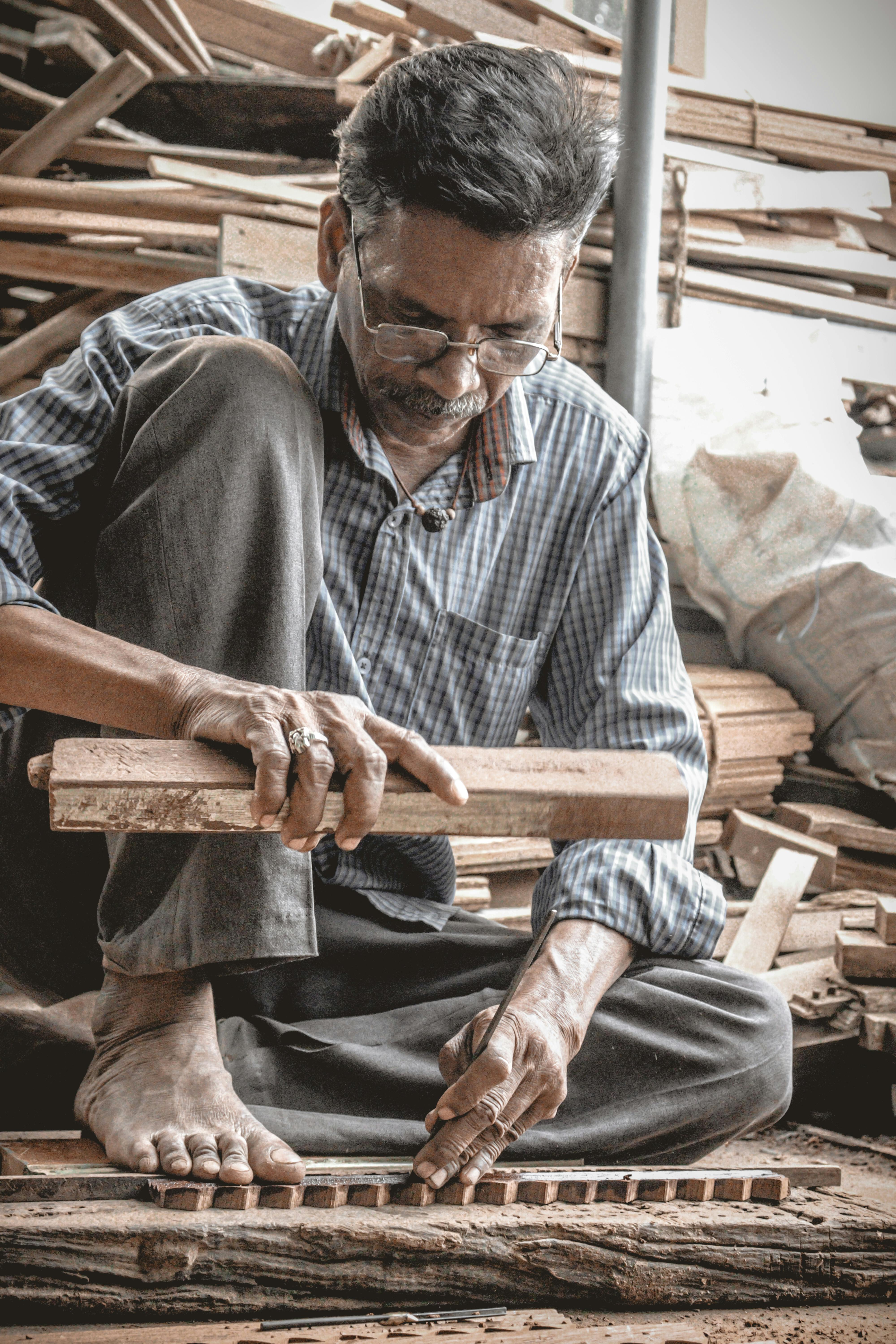 Barefoot Man Working in a Carpentry Studio · Free Stock Photo