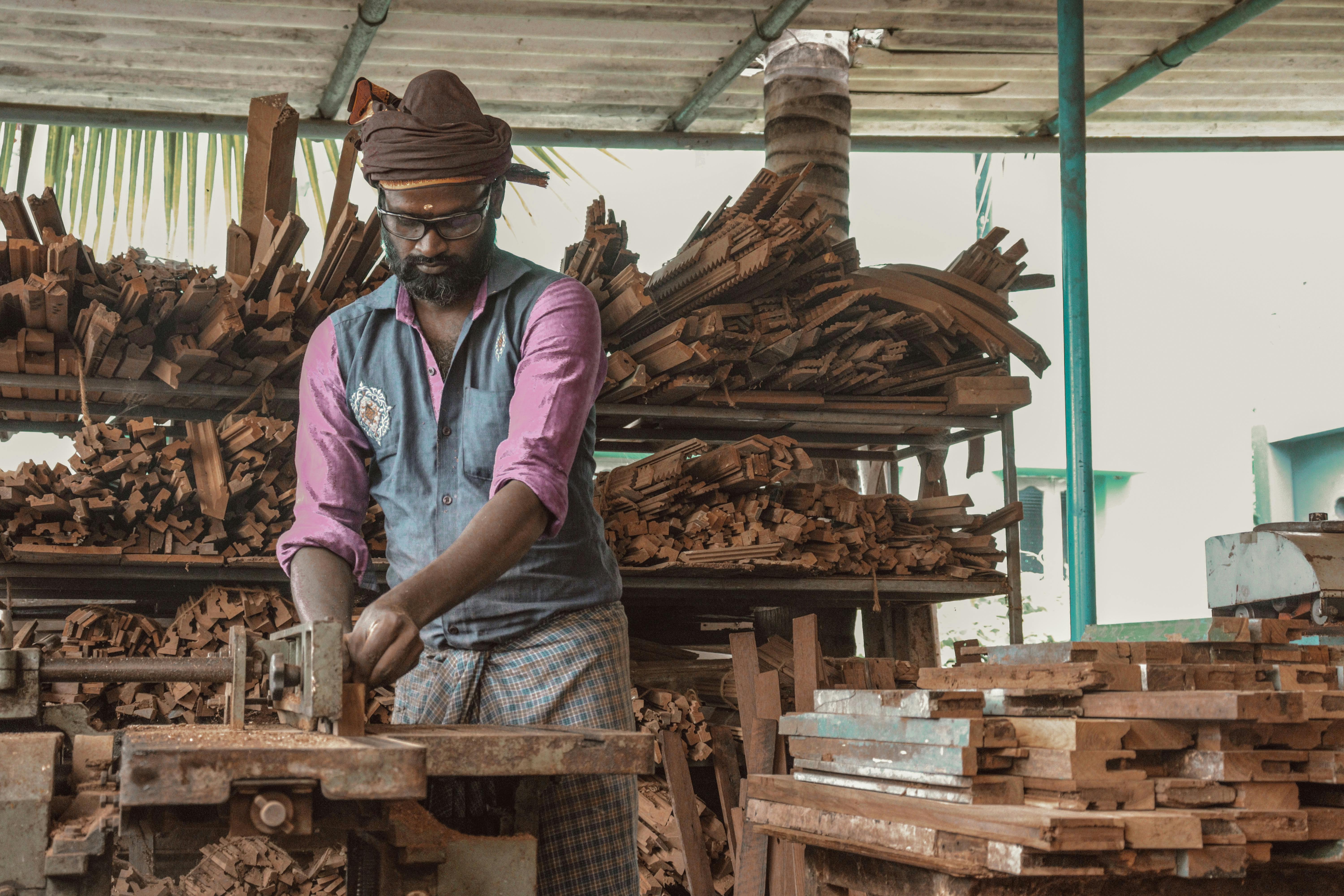 A Carpenter Working with Wood in a Workshop · Free Stock Photo