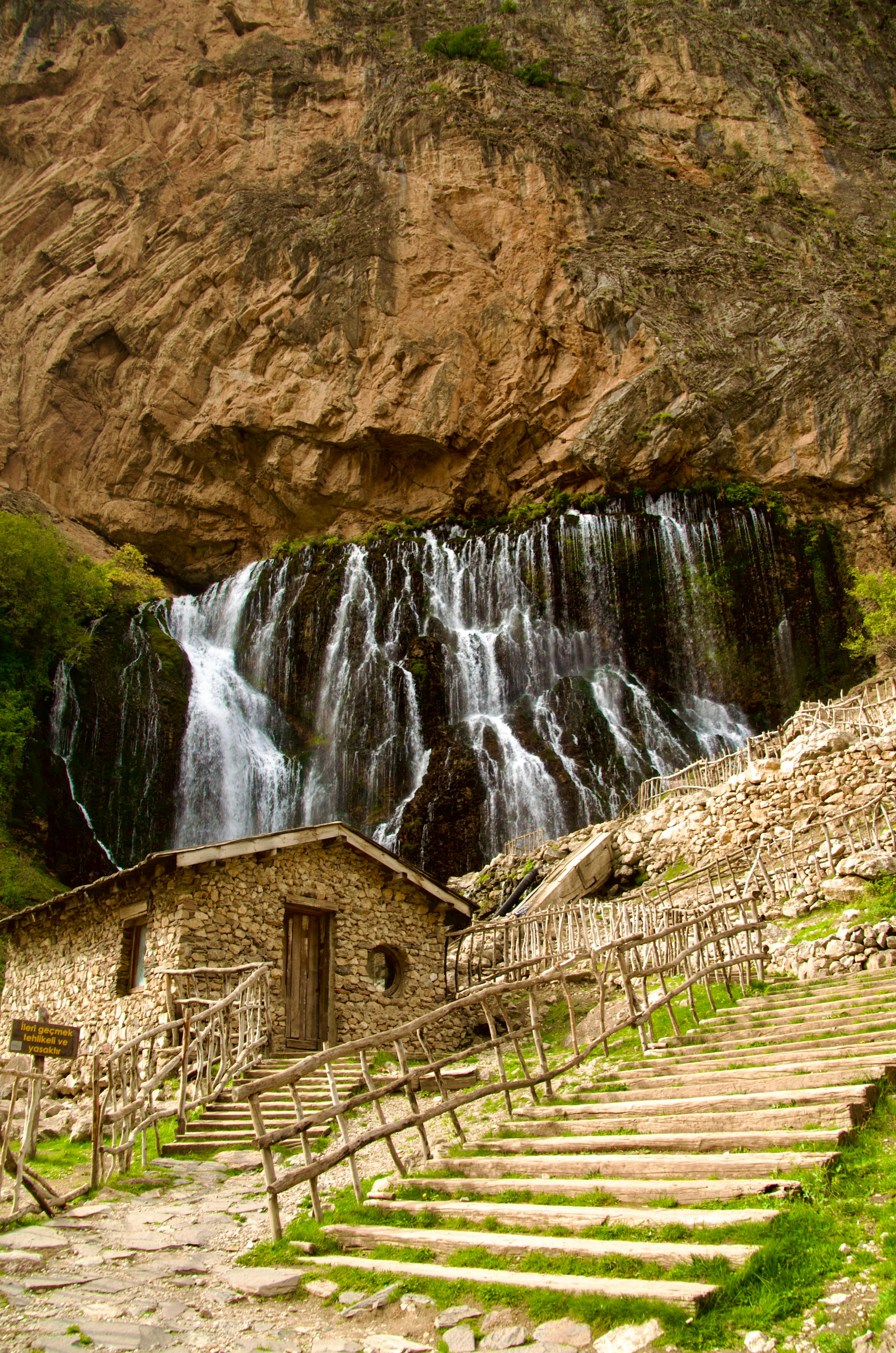 Stone Hut under a Cliff and a Waterfall · Free Stock Photo