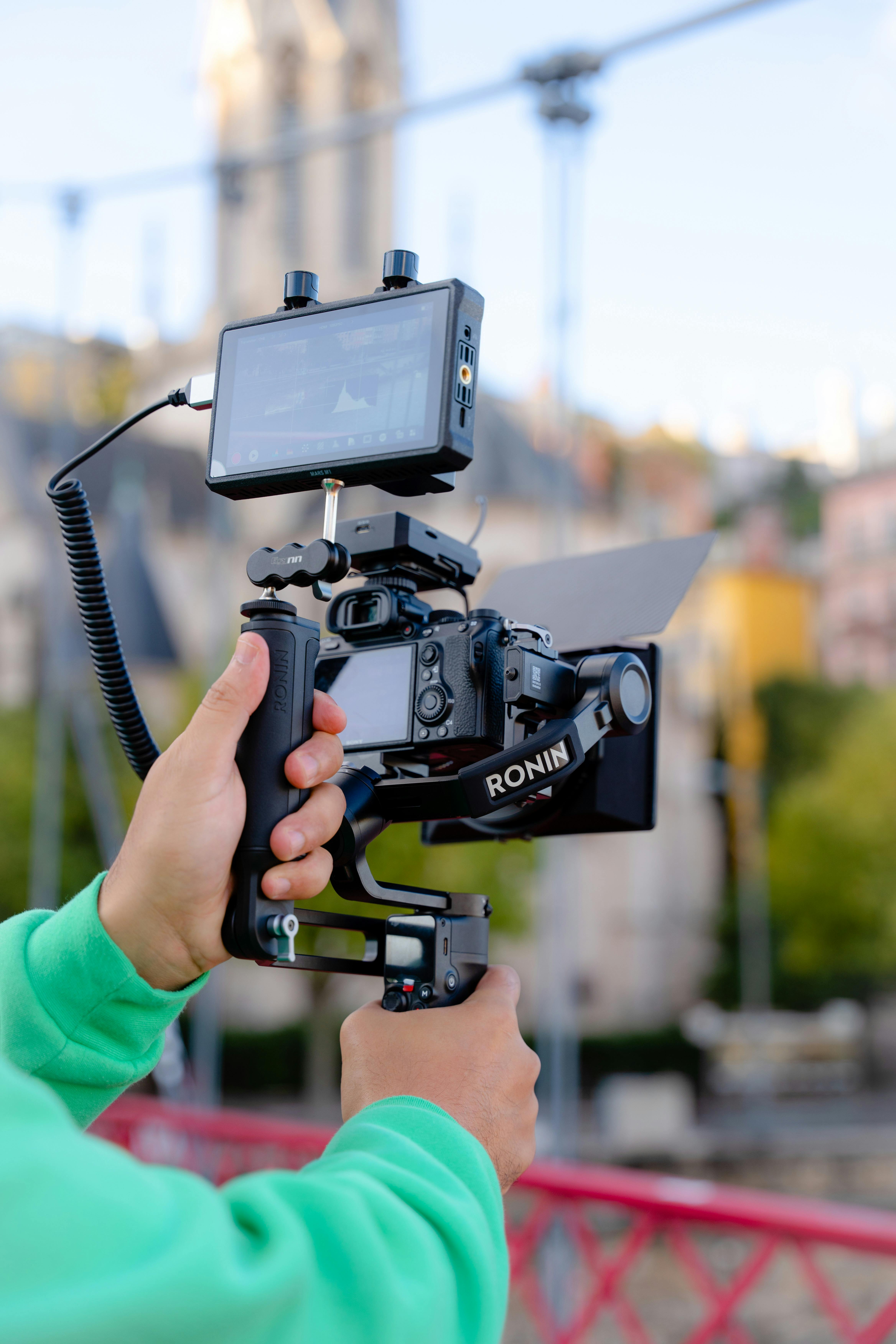 Close-up of a Man Operating a Camera Outside in City · Free Stock Photo