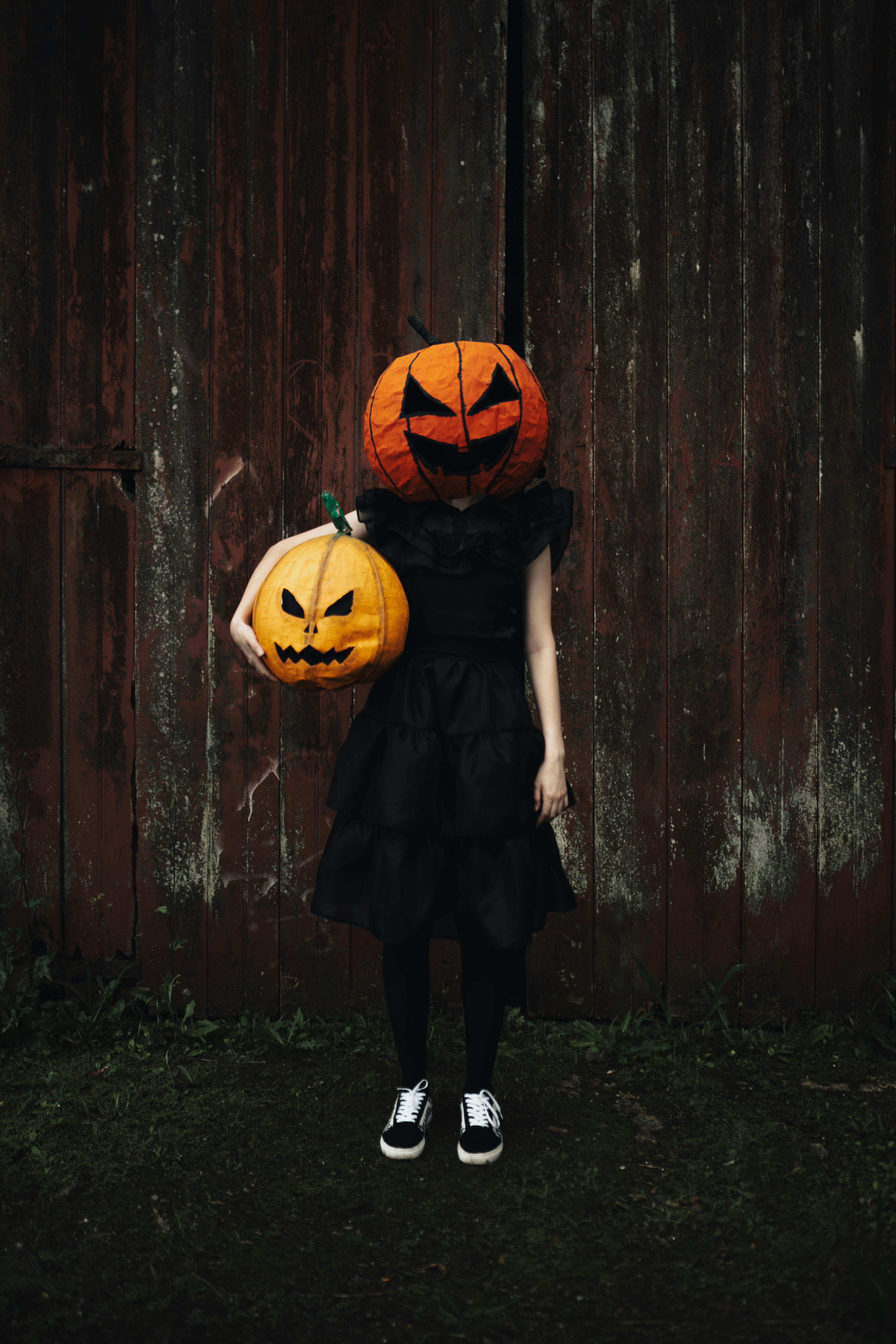 Woman in a Black Dress Wearing a Pumpkin on Her Head and Holding a ...