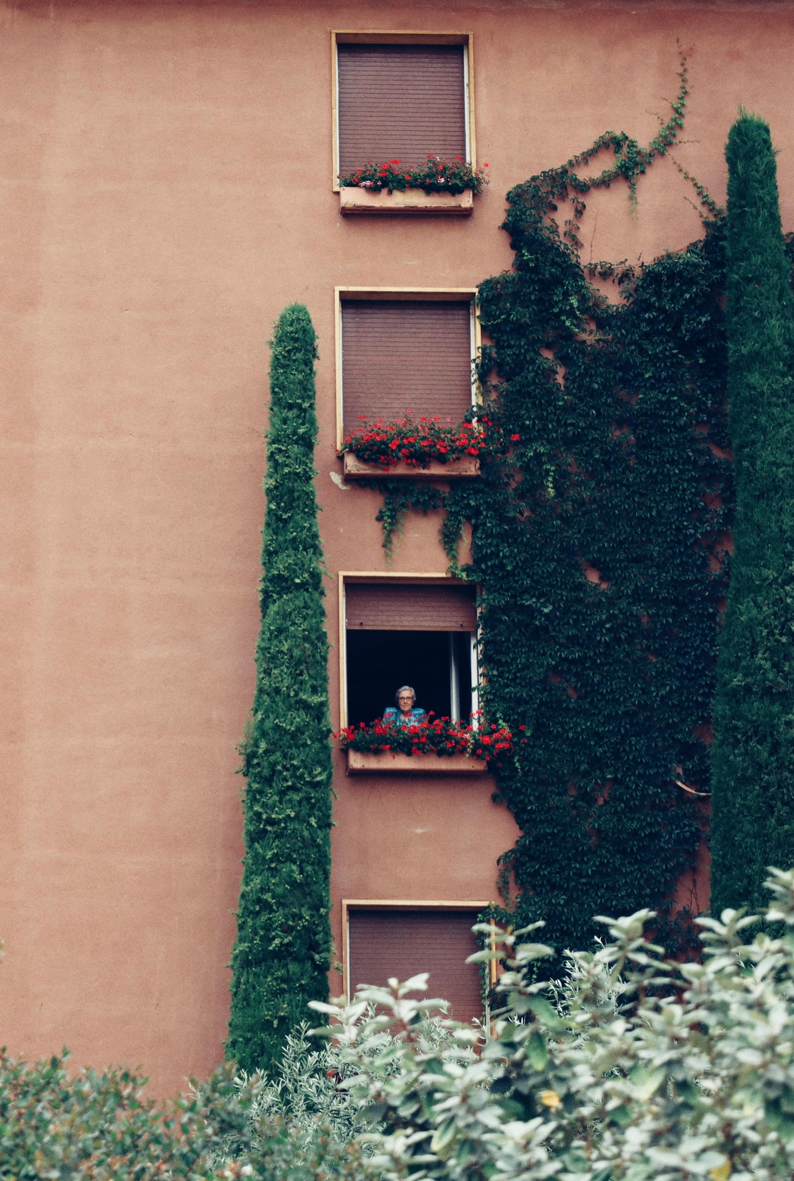 Woman Standing in a Window of a Multi-Storey Residential Building in ...