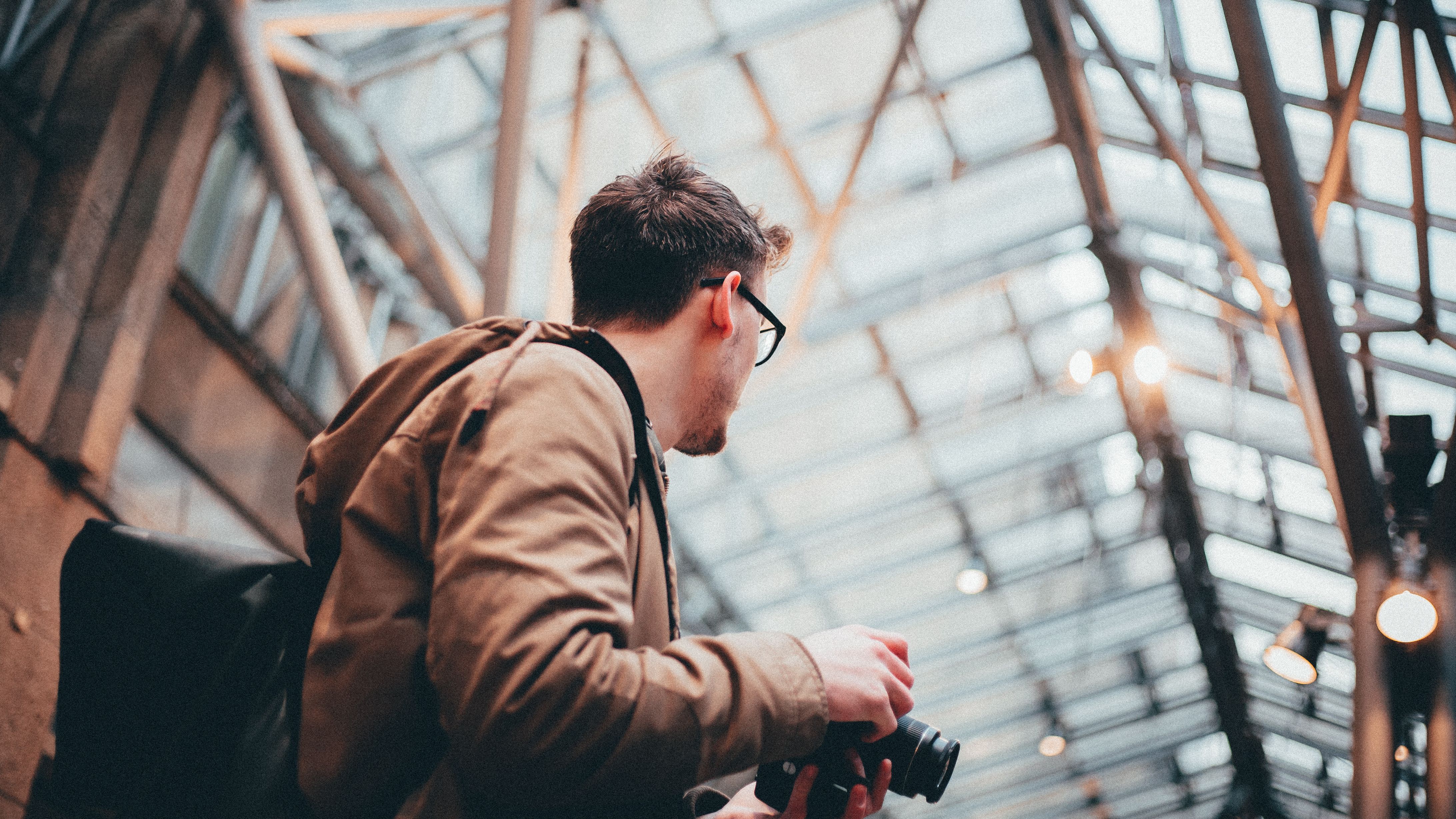 Man Standing While Holding Black Dslr Camera · Free Stock Photo