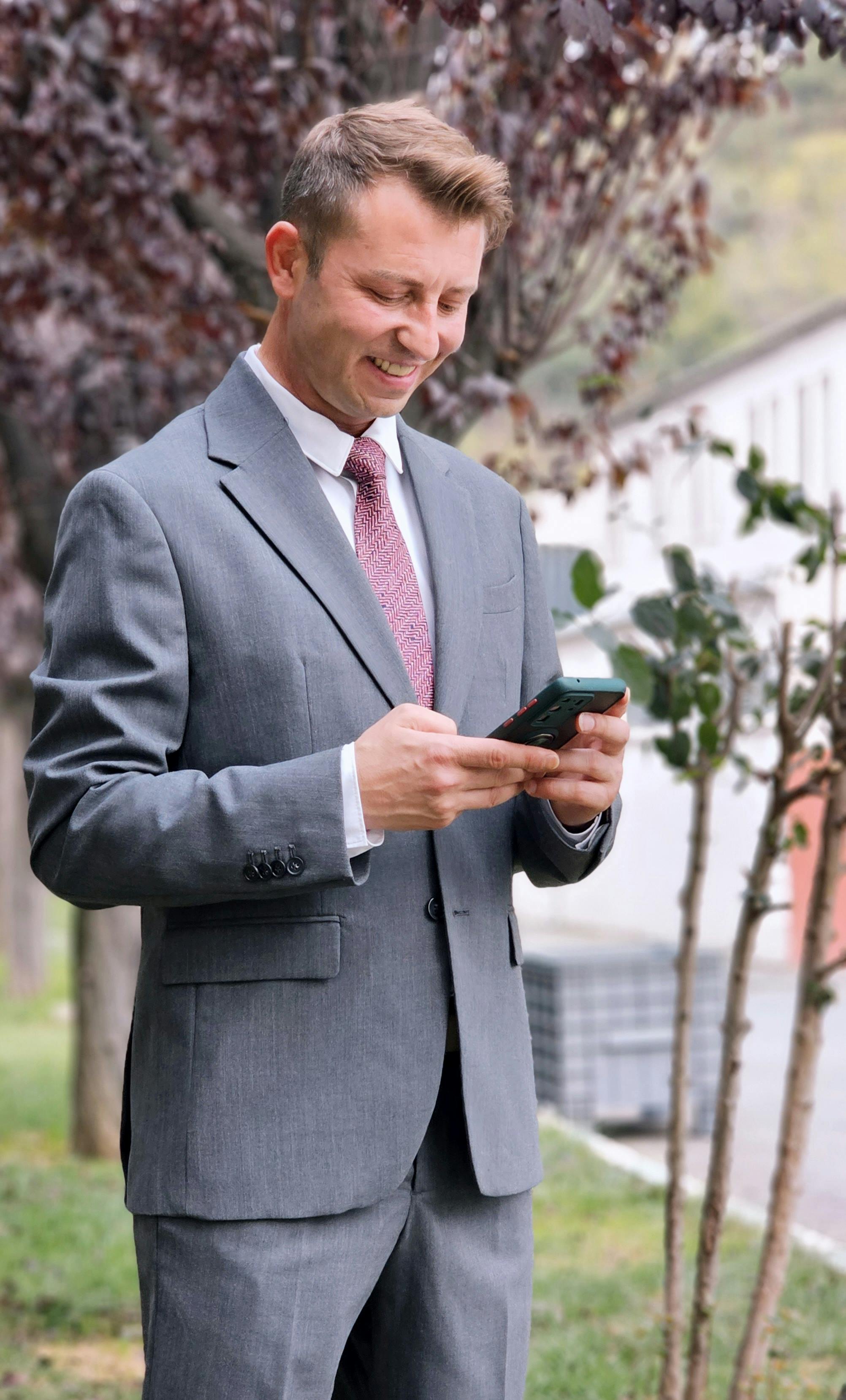 Man in Gray Suit Texting on Smartphone · Free Stock Photo