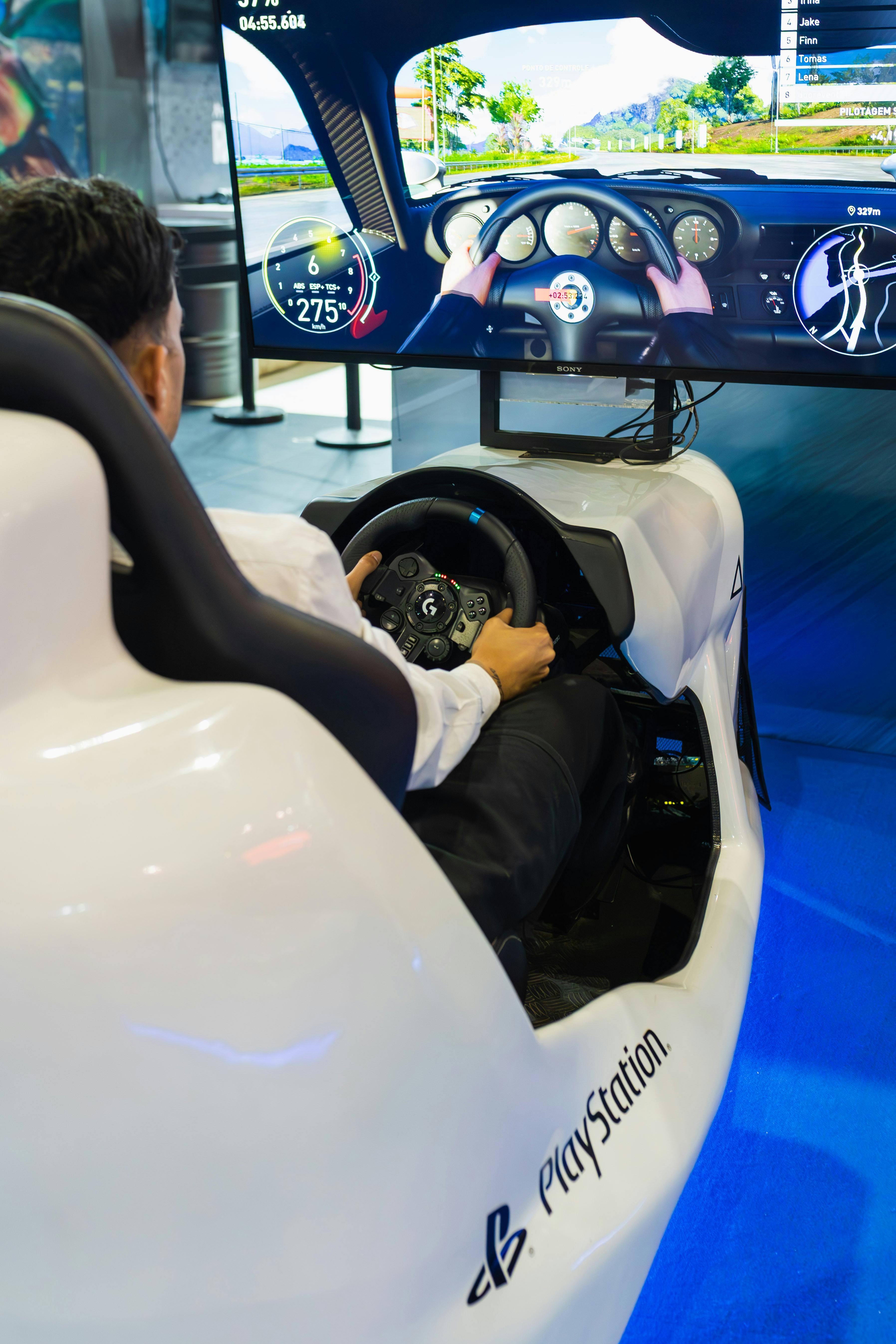 Gamer Sitting in a PlayStation Racing Simulator with a Logitech Racing ...