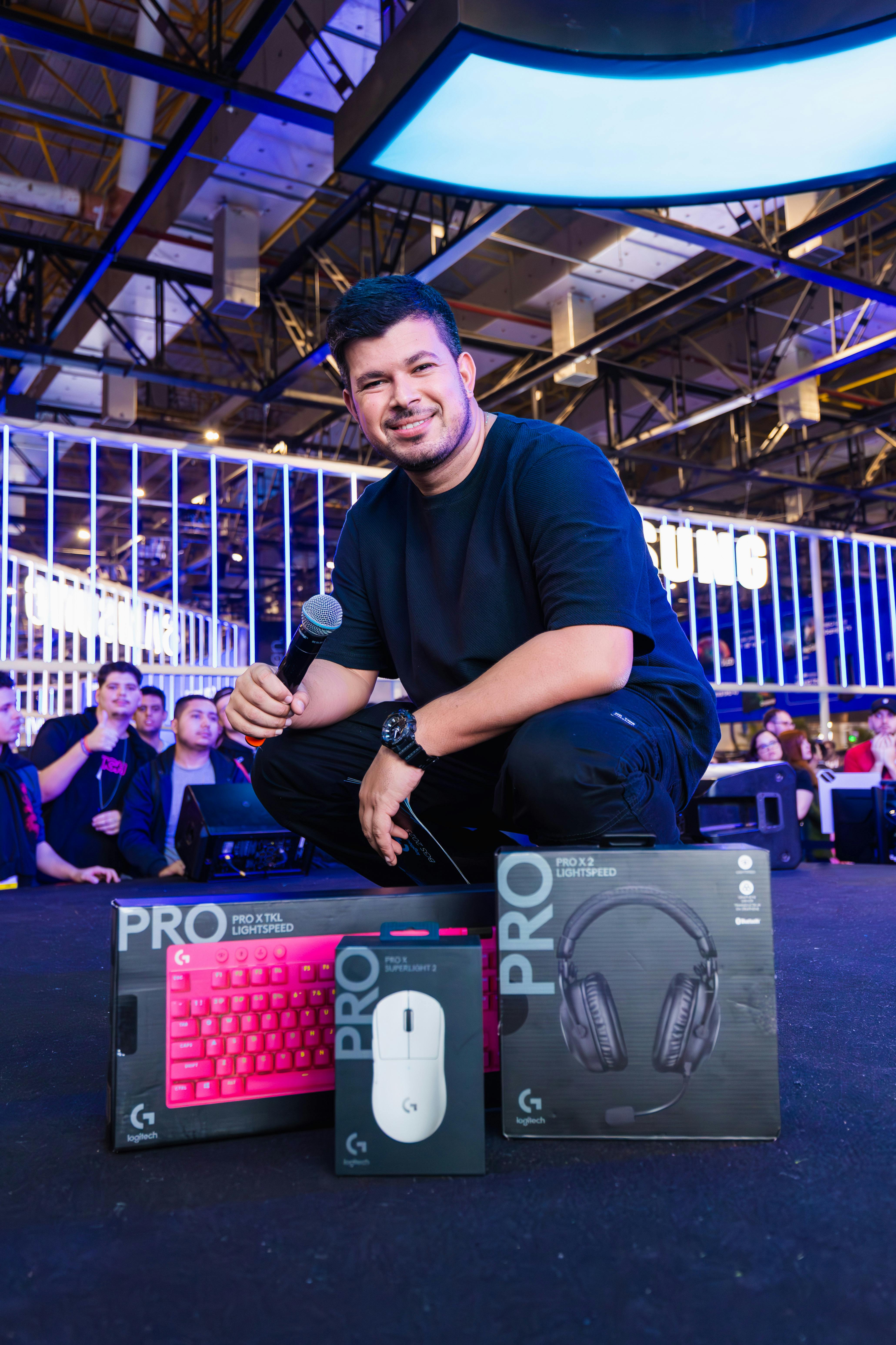 Man with a Microphone Next to Boxes with Logitech Gaming Peripherals at ...