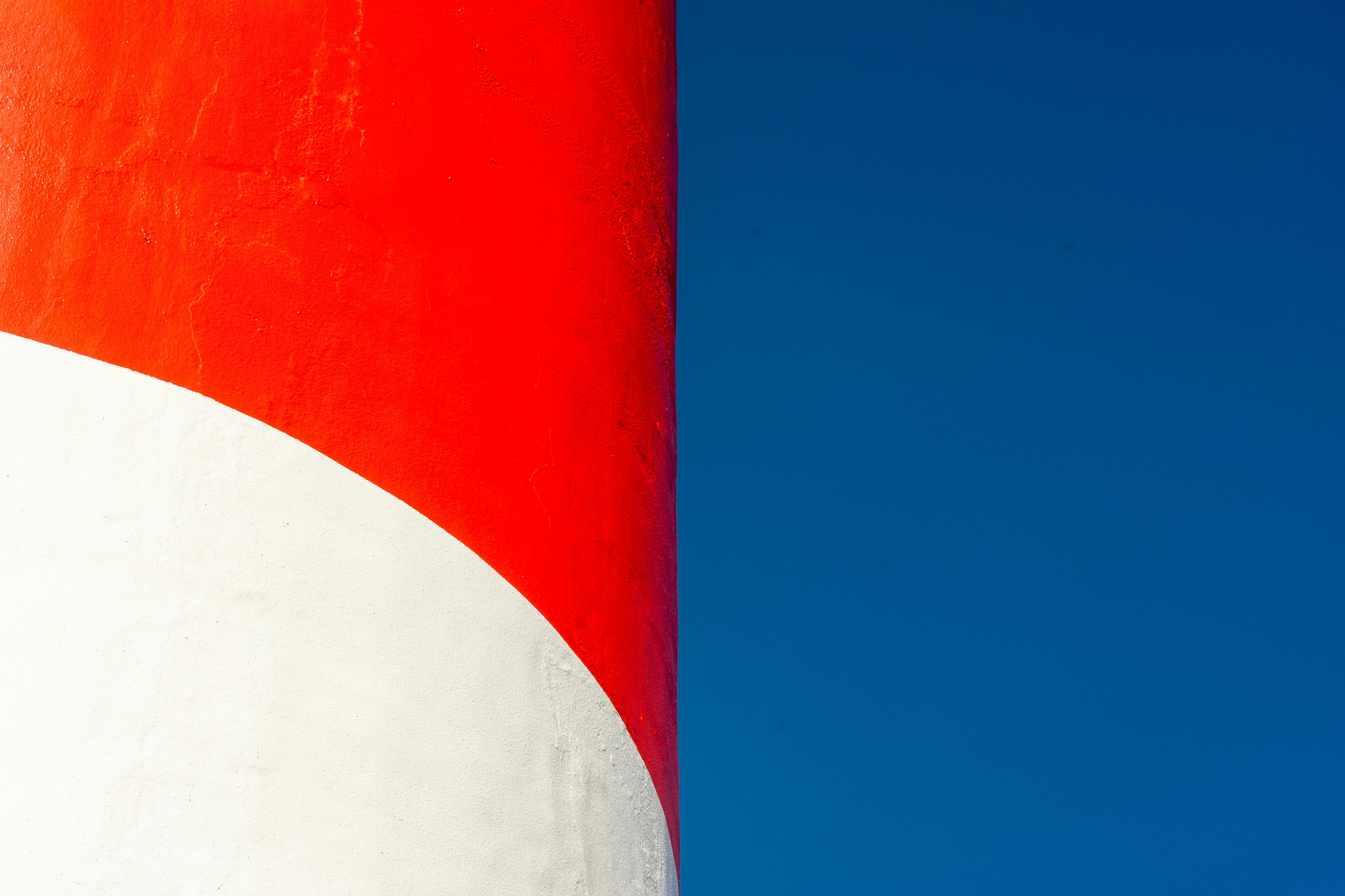 Facade of a Red and White Round Building with a Blue Sky in the ...