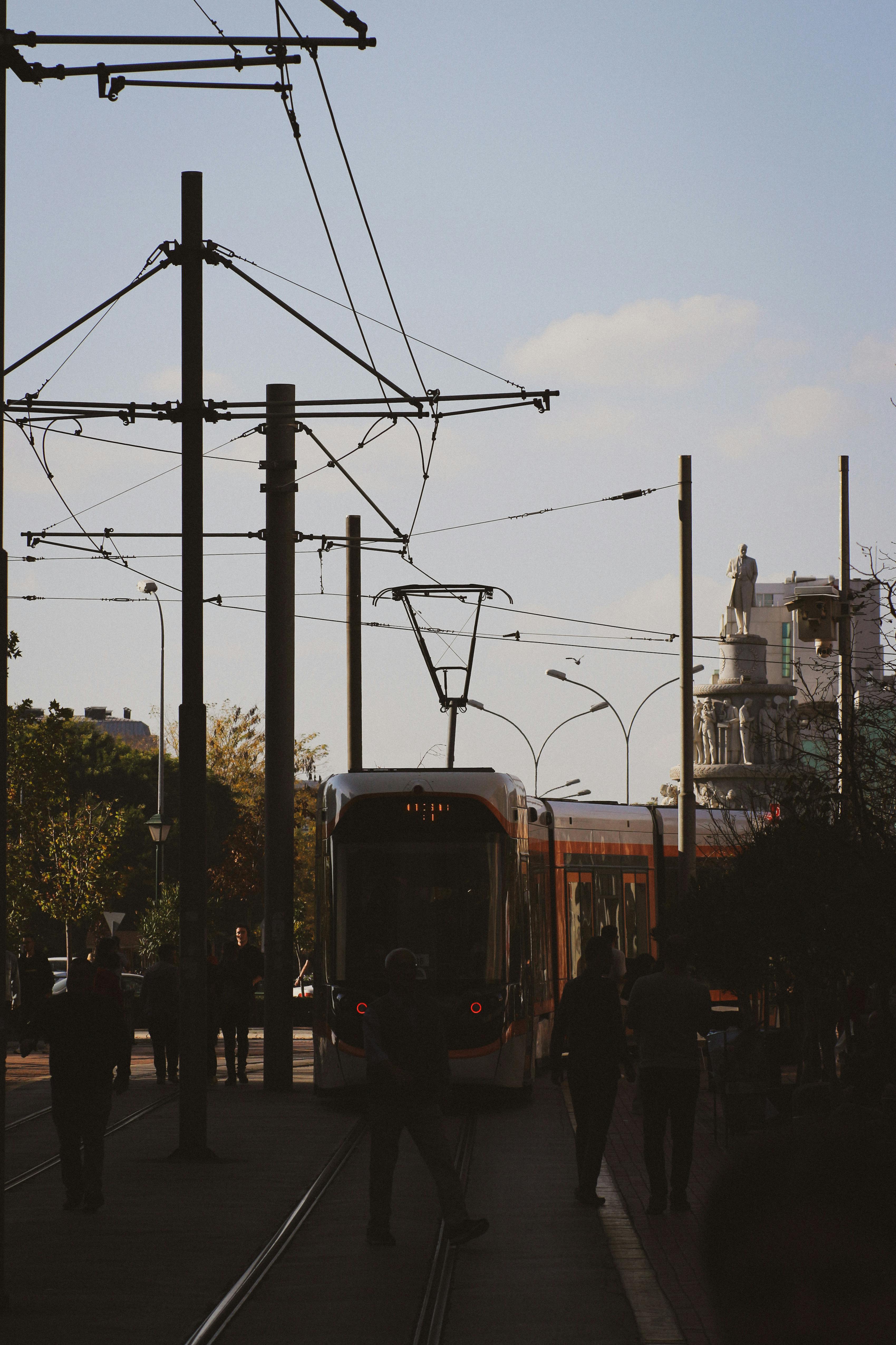 Tram behind People in Shadow in Town · Free Stock Photo