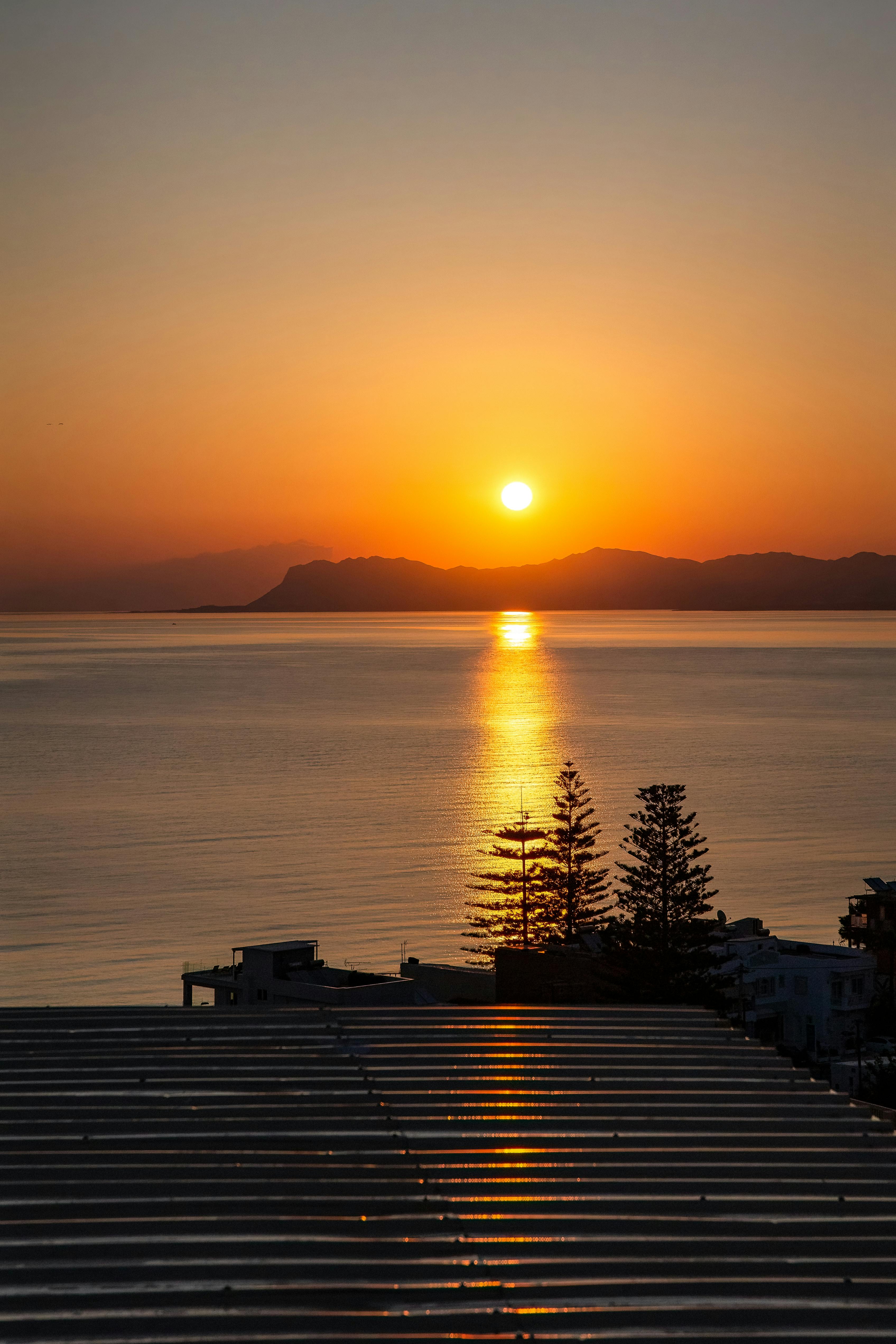 Sunset over Roof of Building on Sea Shore · Free Stock Photo