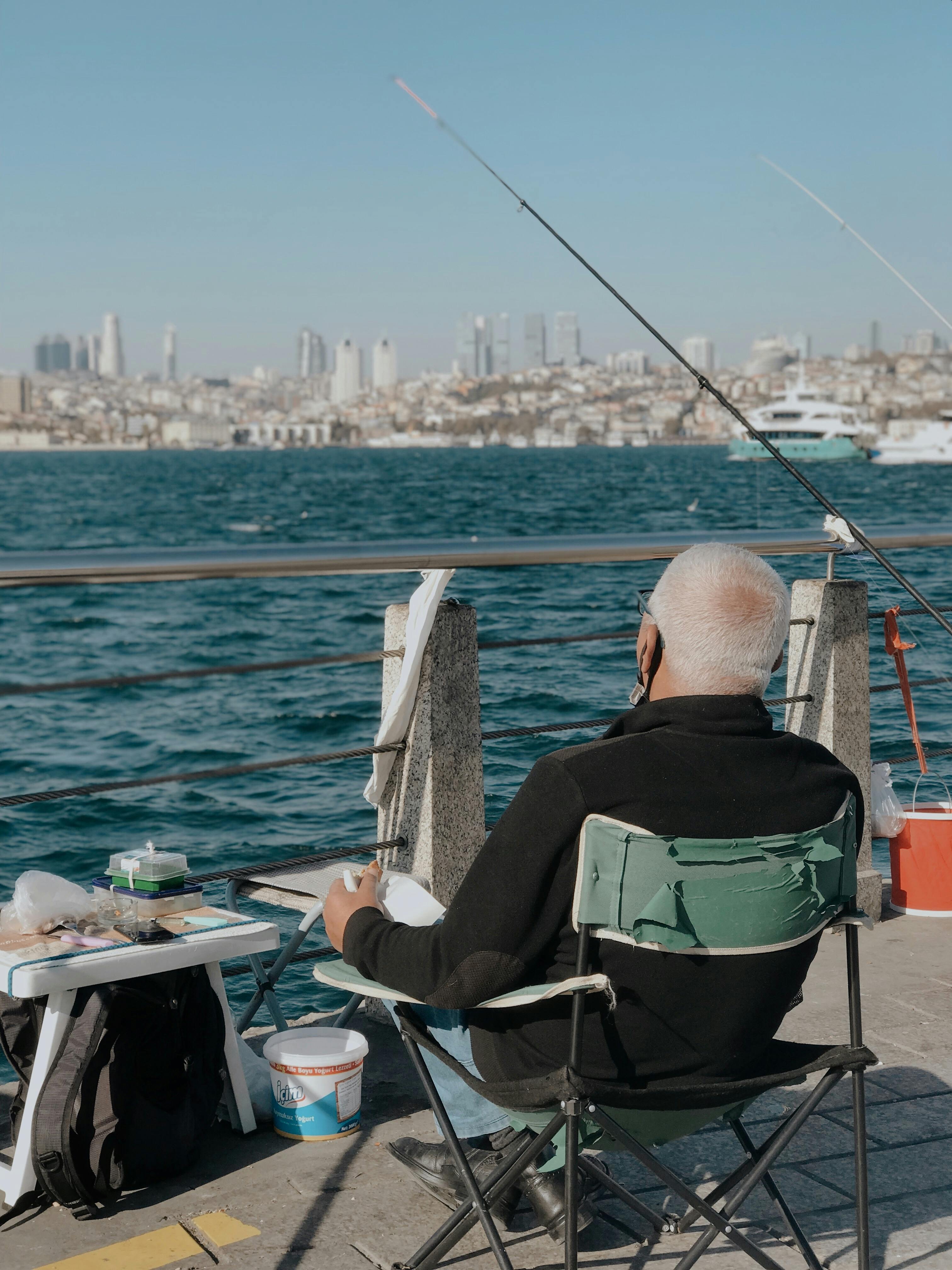 Back View of a Man Fishing from a Pier · Free Stock Photo