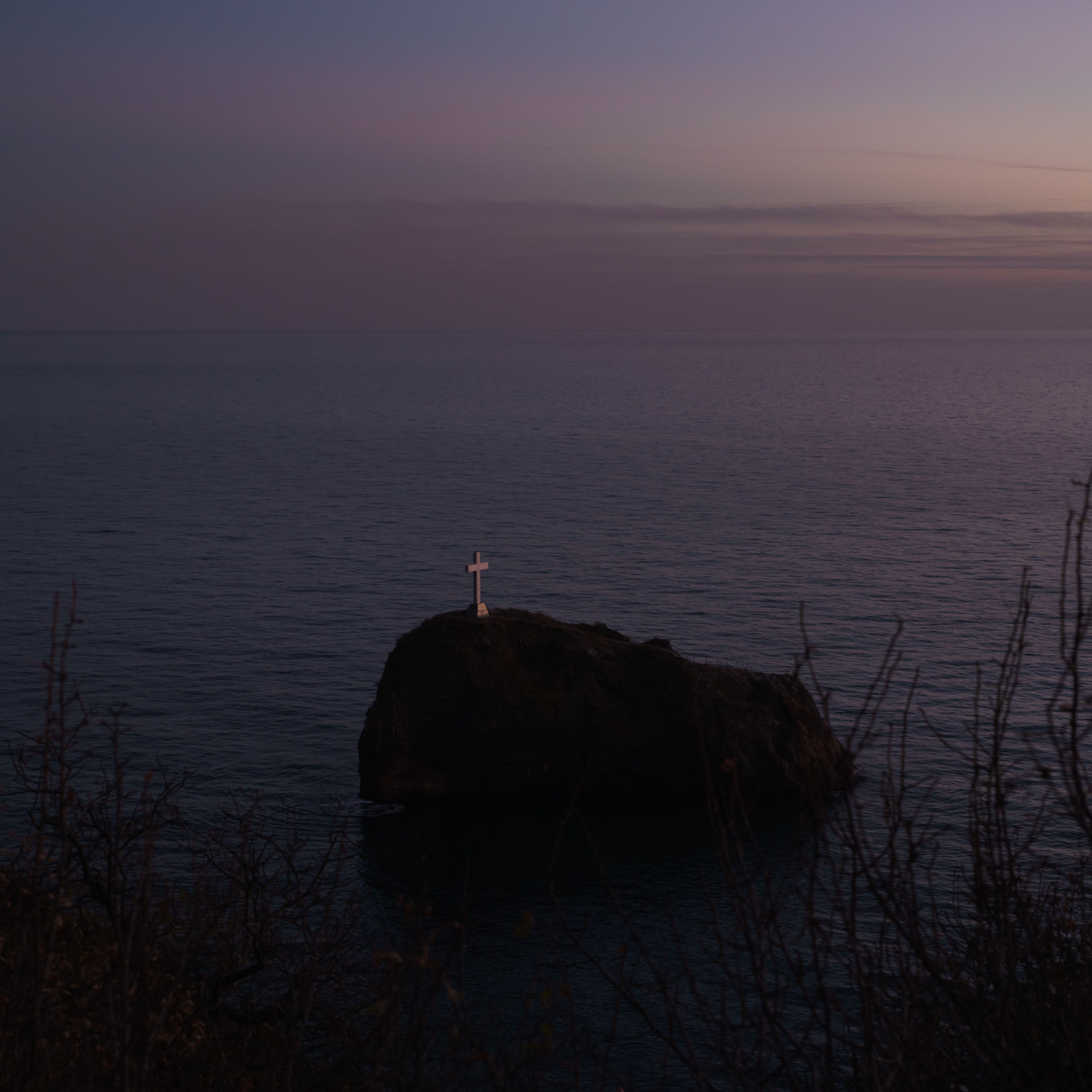 Cross on Rock on Sea Shore at Dusk · Free Stock Photo