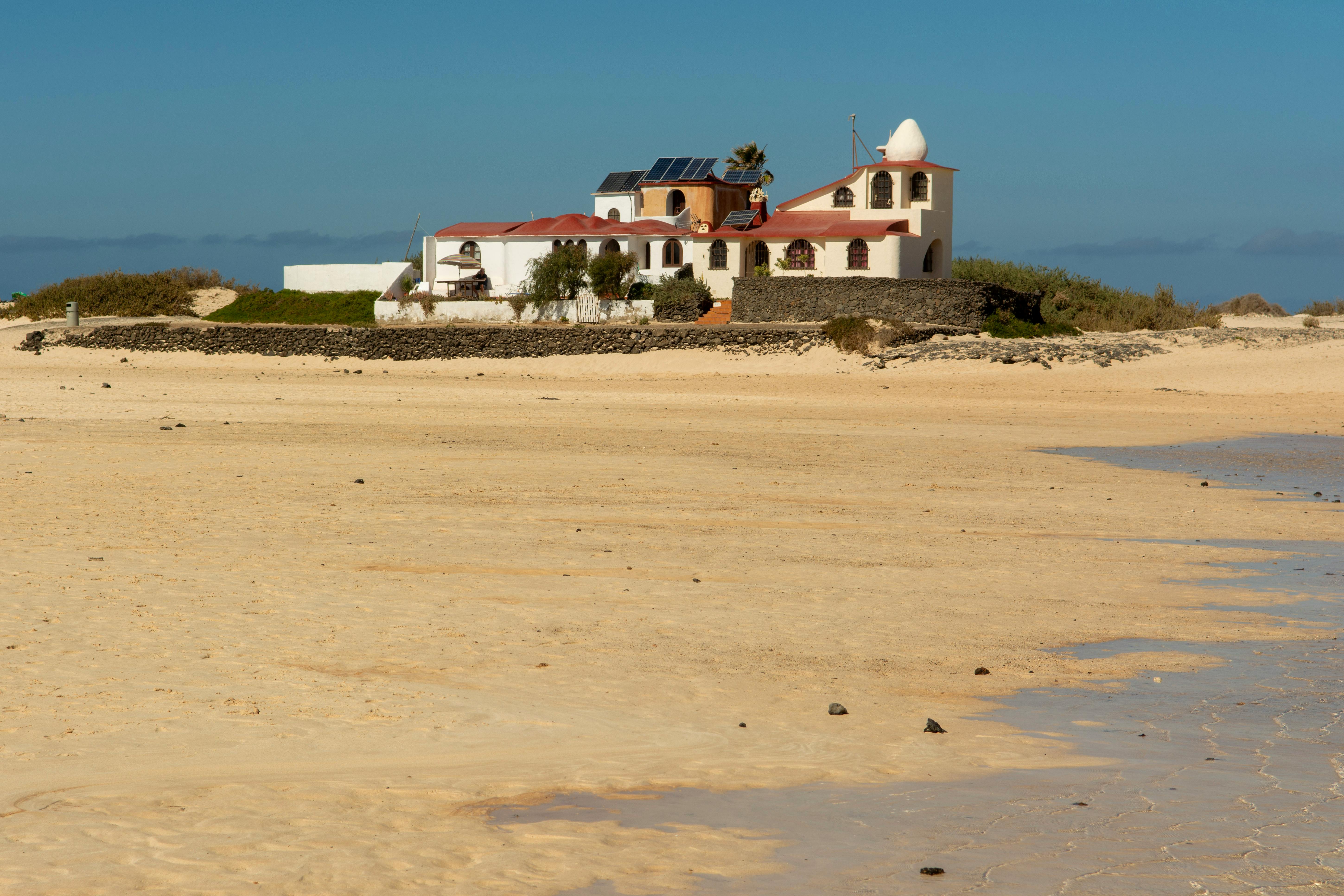 Building behind Beach on Sea Shore · Free Stock Photo