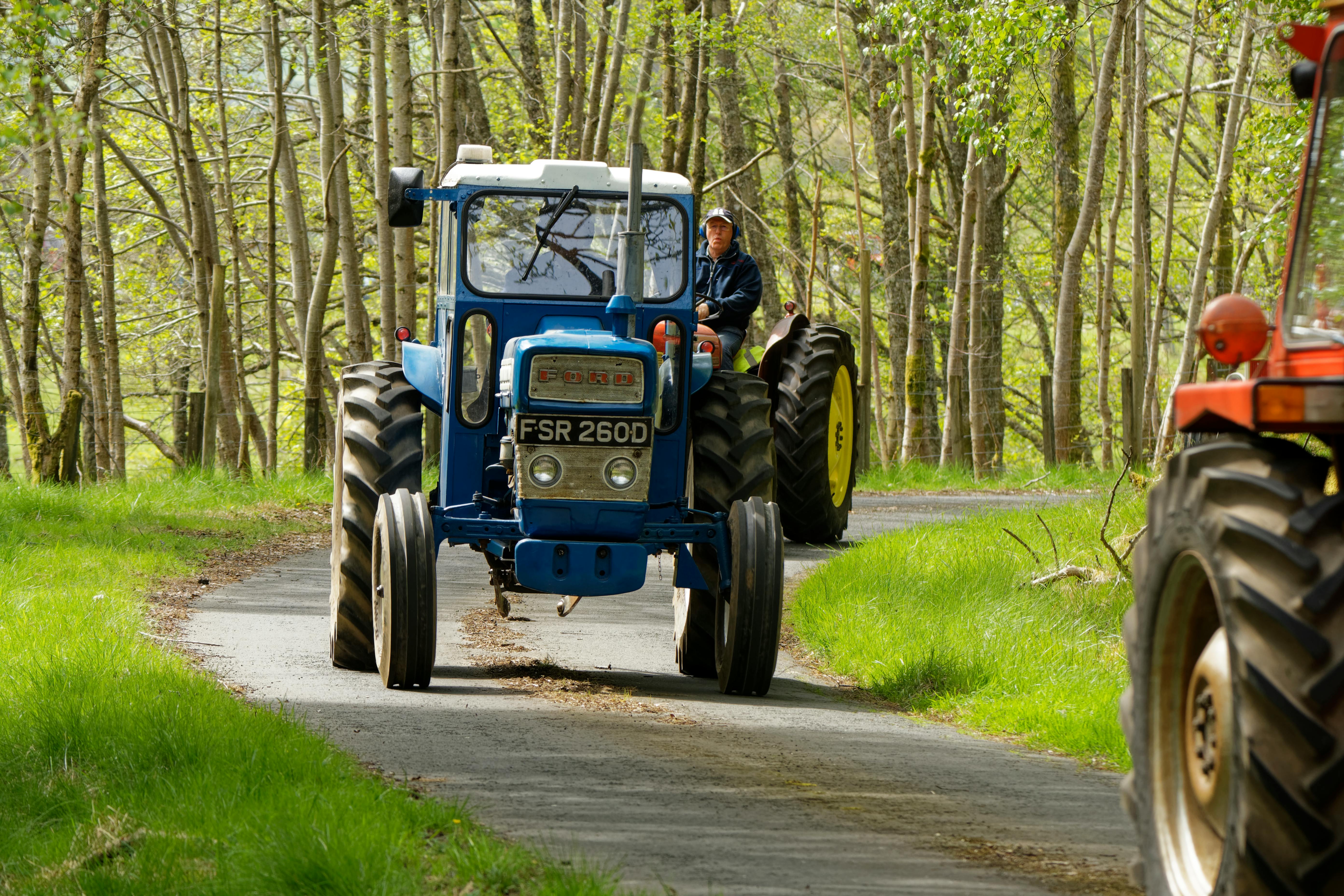 Tractors on the Road between Trees · Free Stock Photo