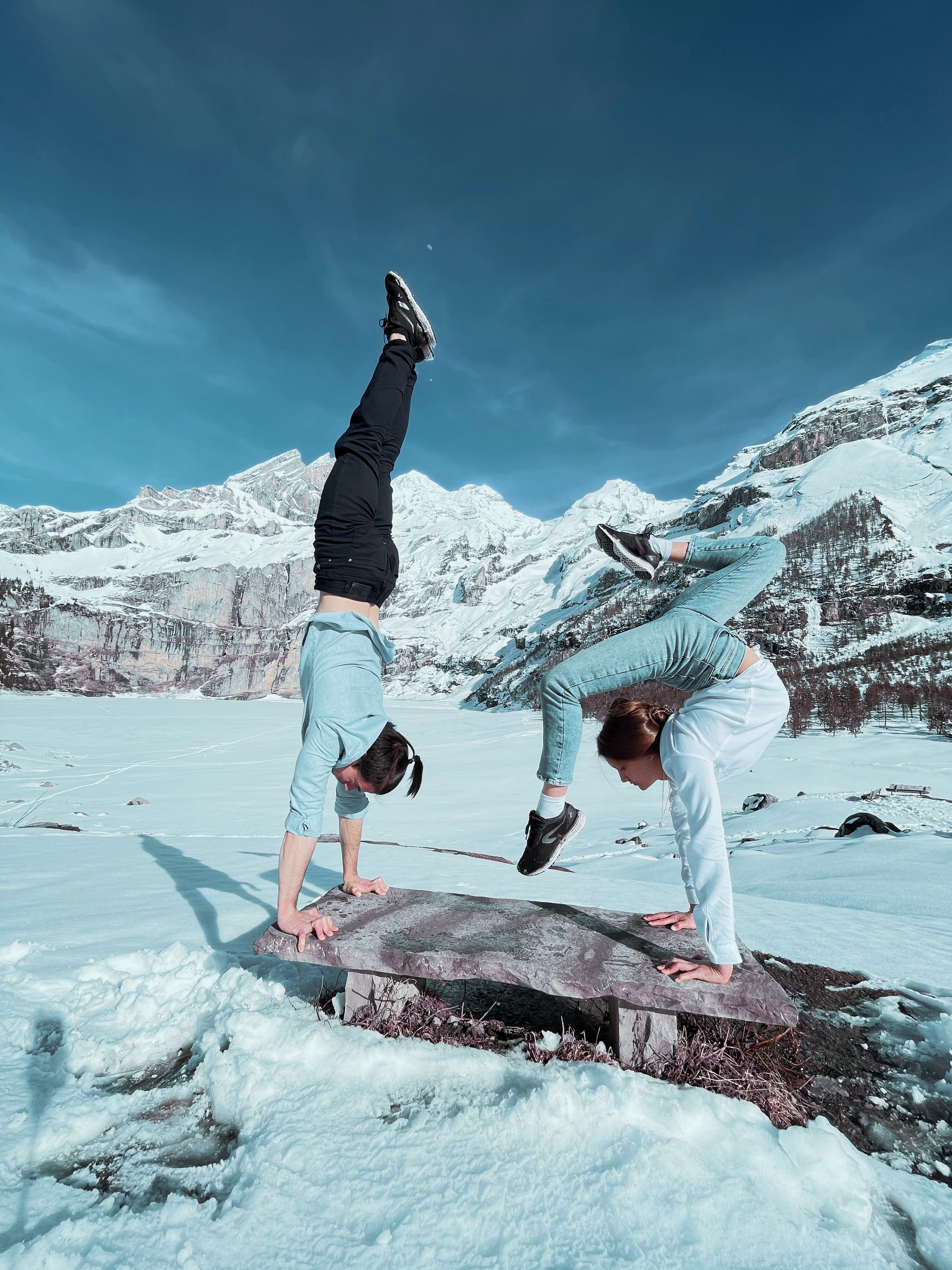 Woman and Man Posing in Handstand on Platform on Snow · Free Stock Photo