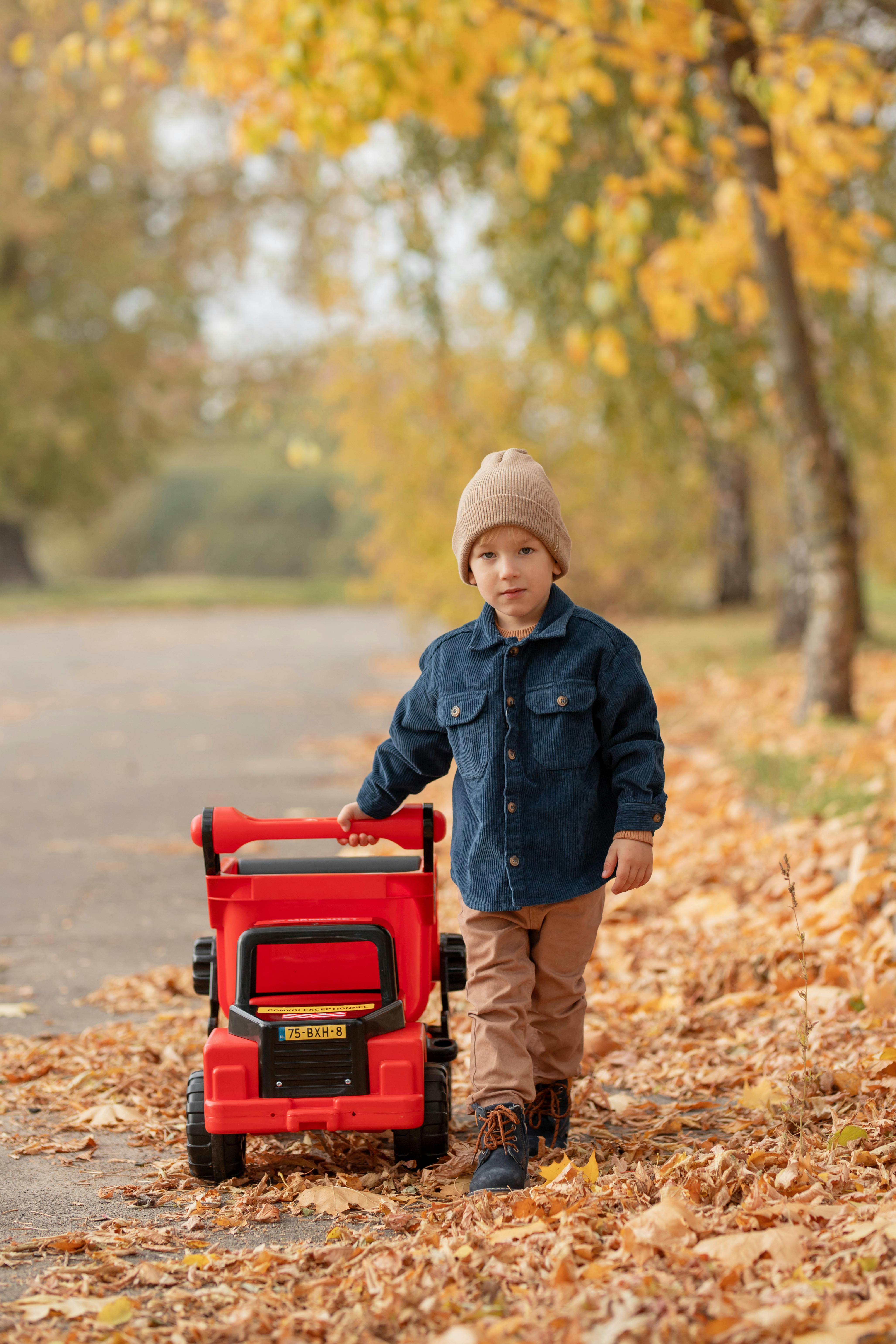 Boy with Toy Truck on Autumn Leaves · Free Stock Photo
