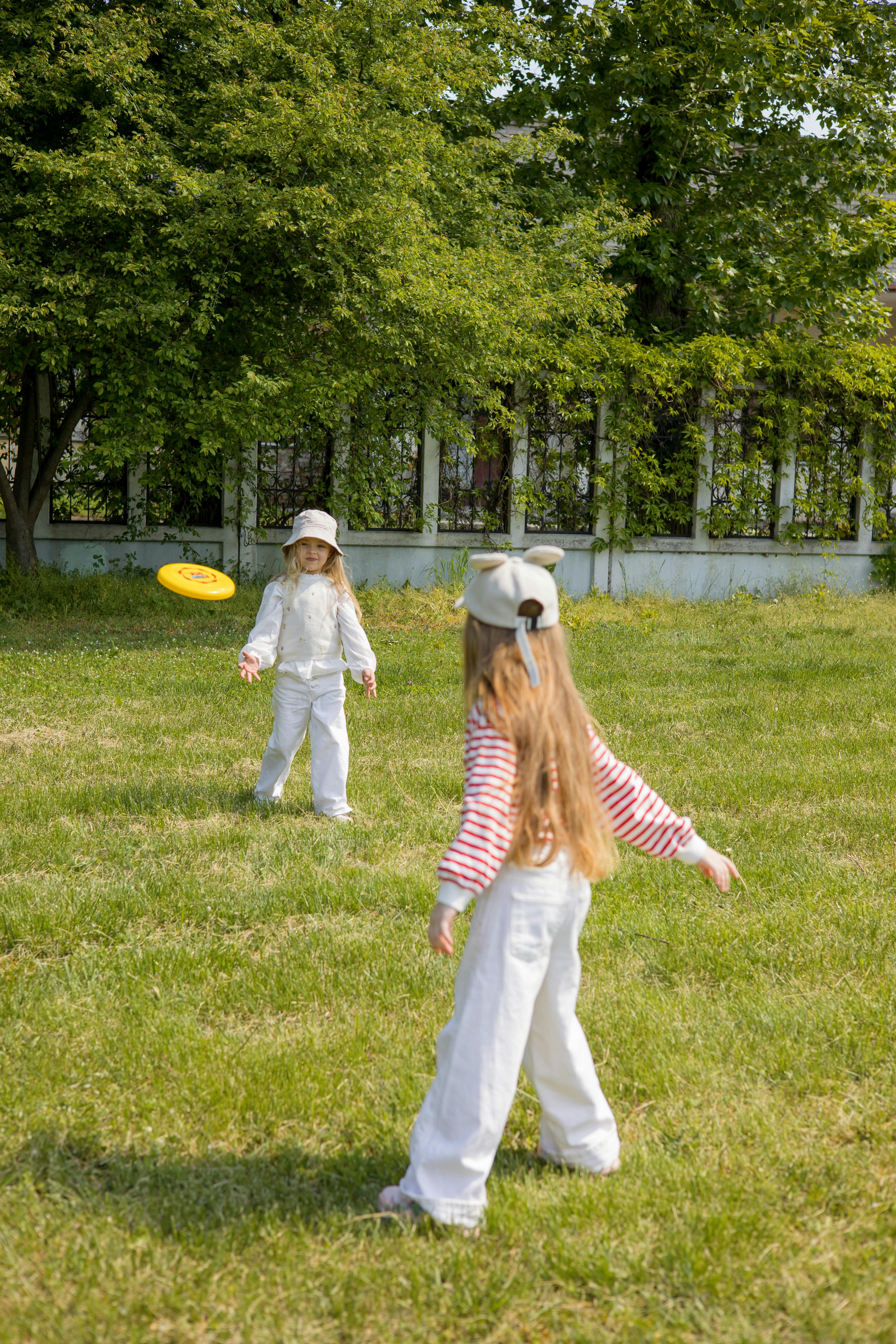 Little Girls Throwing Frisbee in a Park · Free Stock Photo
